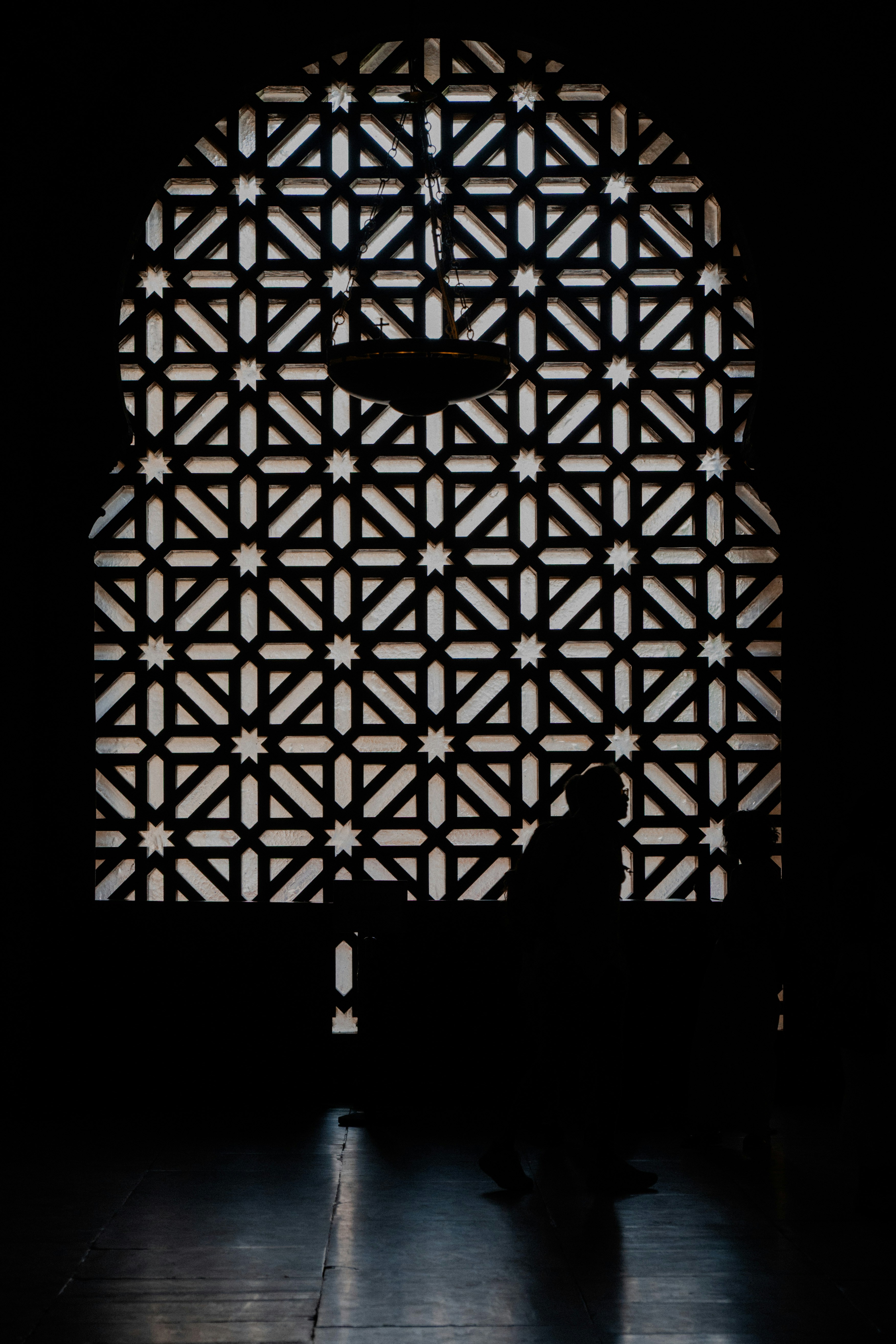 Silhouette Beneath a Geometric Window: Quiet Architecture at Dusk