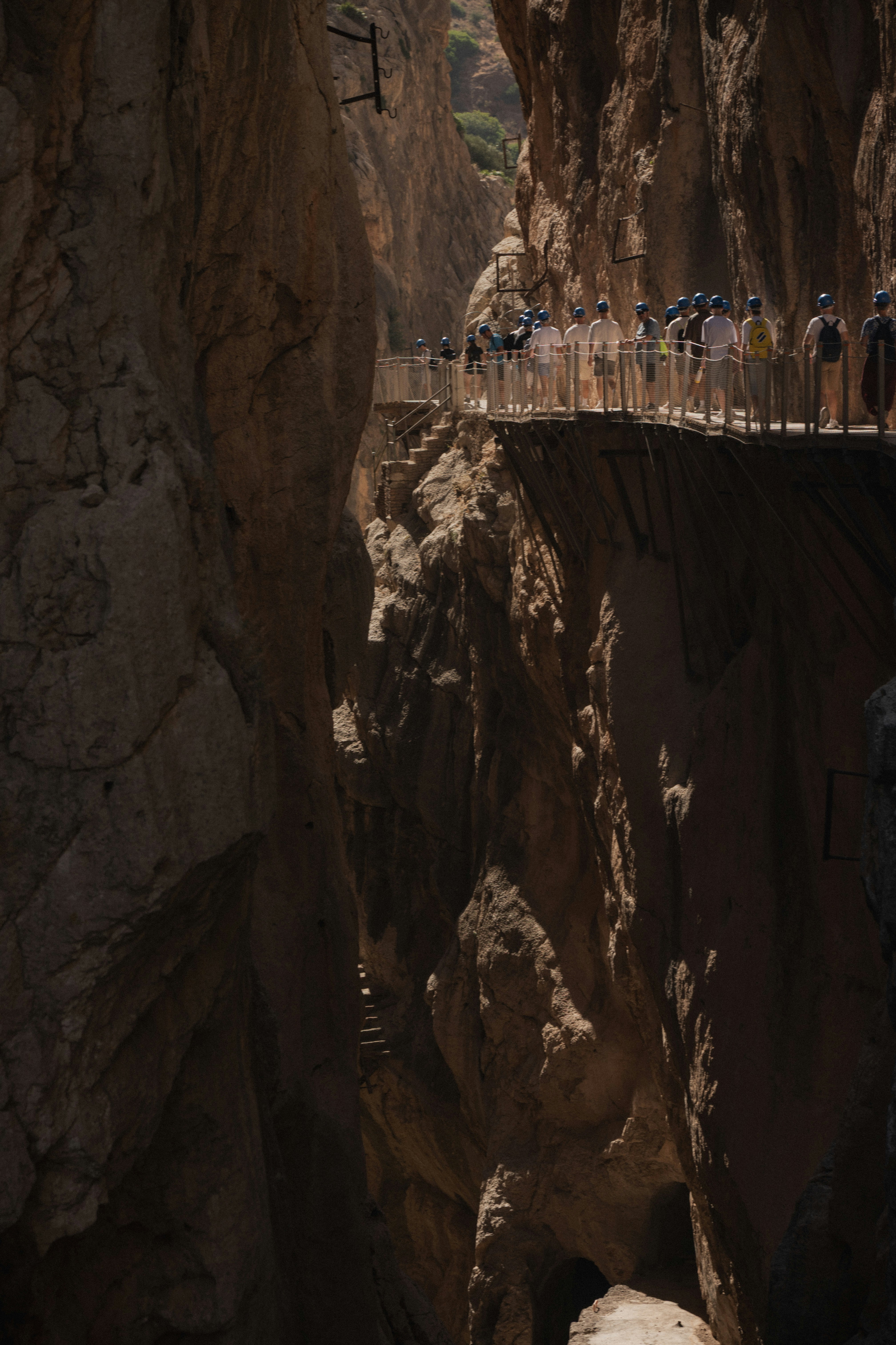 Suspended Vista: Tourists Traverse a Cliffside Walkway Above a Narrow Canyon