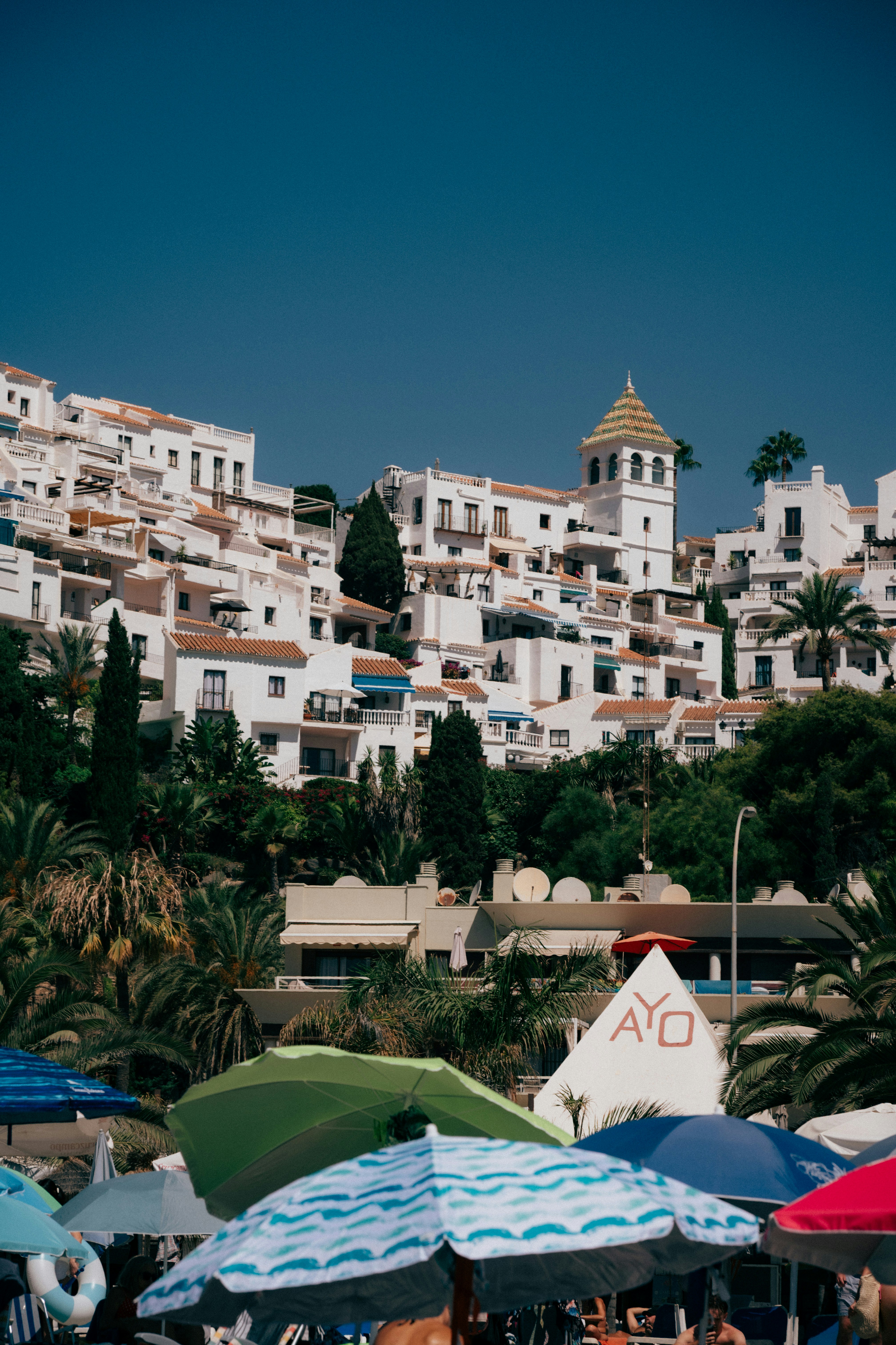 Whitewashed hillside chalets under a blue Spanish sky