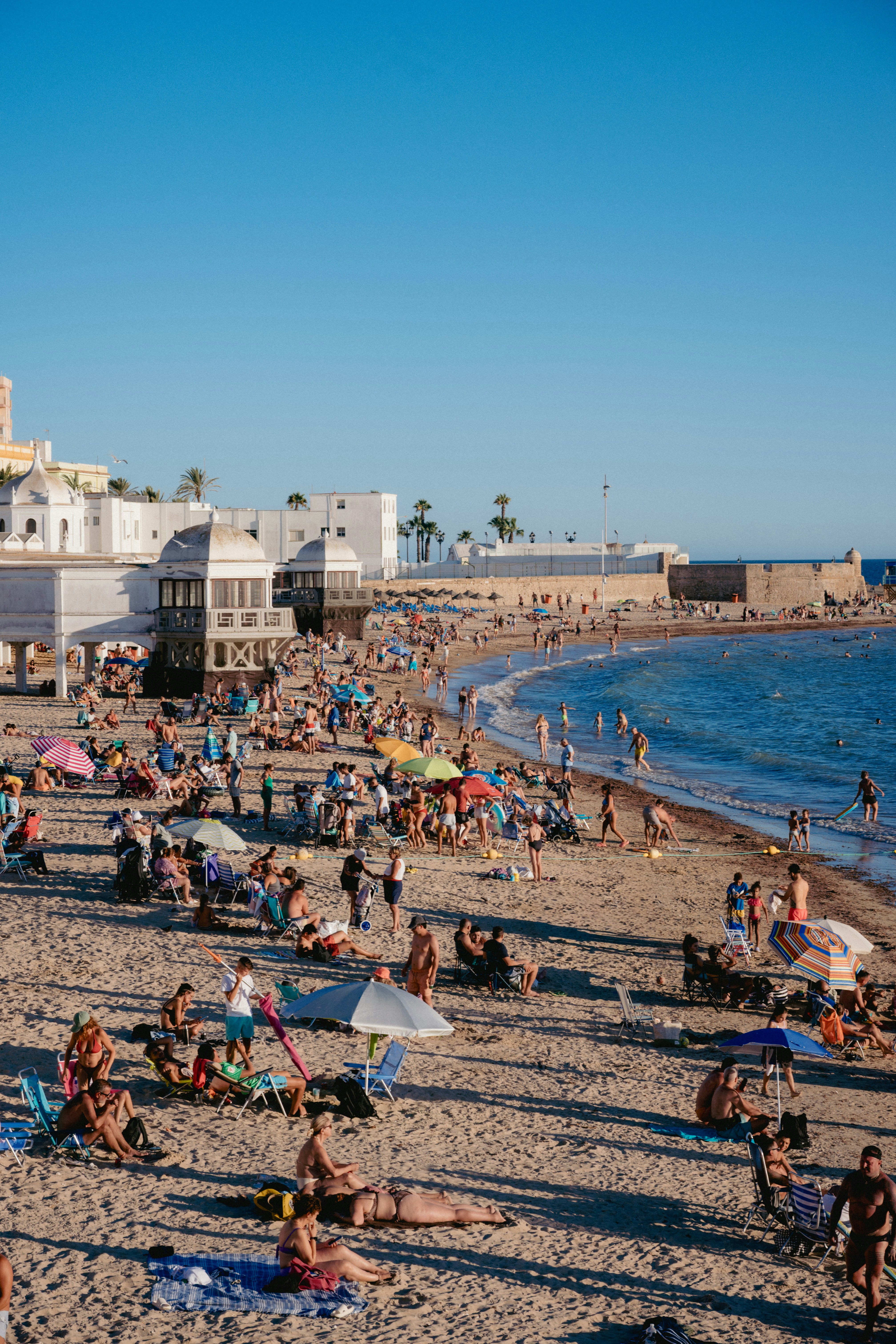 Sunlit Riviera Sojourn: A Bustling Beachfront in Late Afternoon