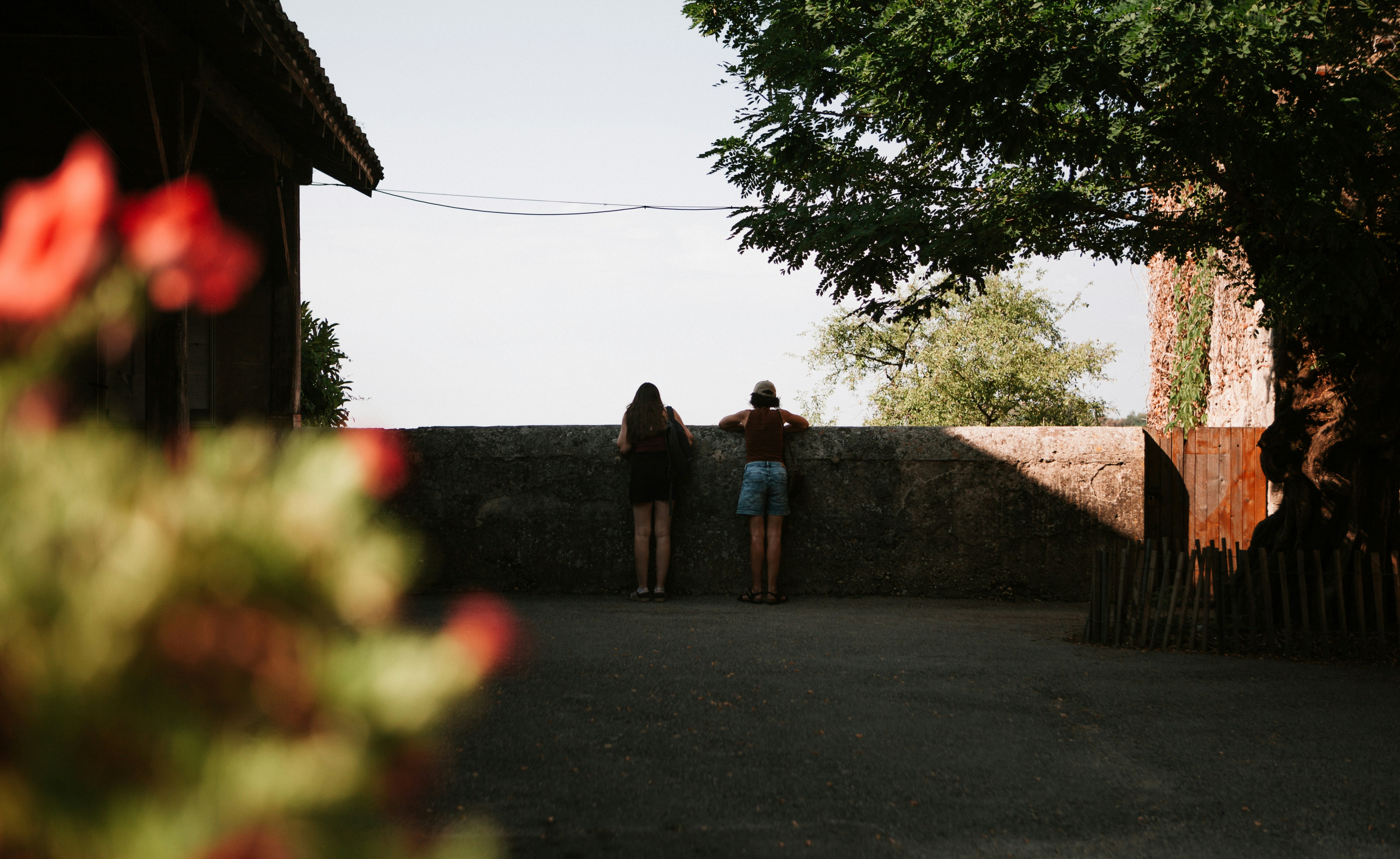 Two Silhouettes at Sunset Above A Walled Terrace