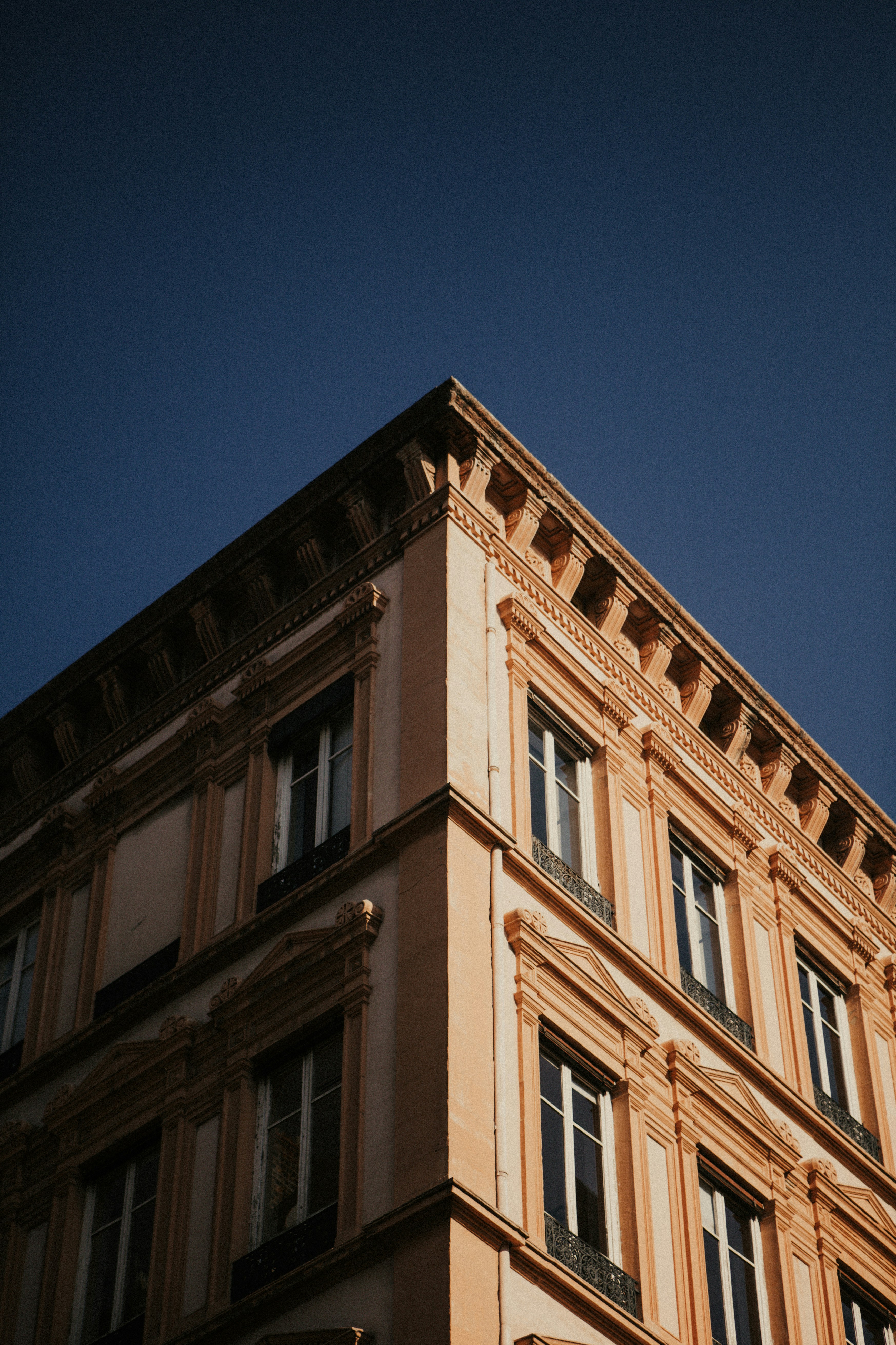 Sunlit Corner: A Classic Building Rising into a Clear Sky