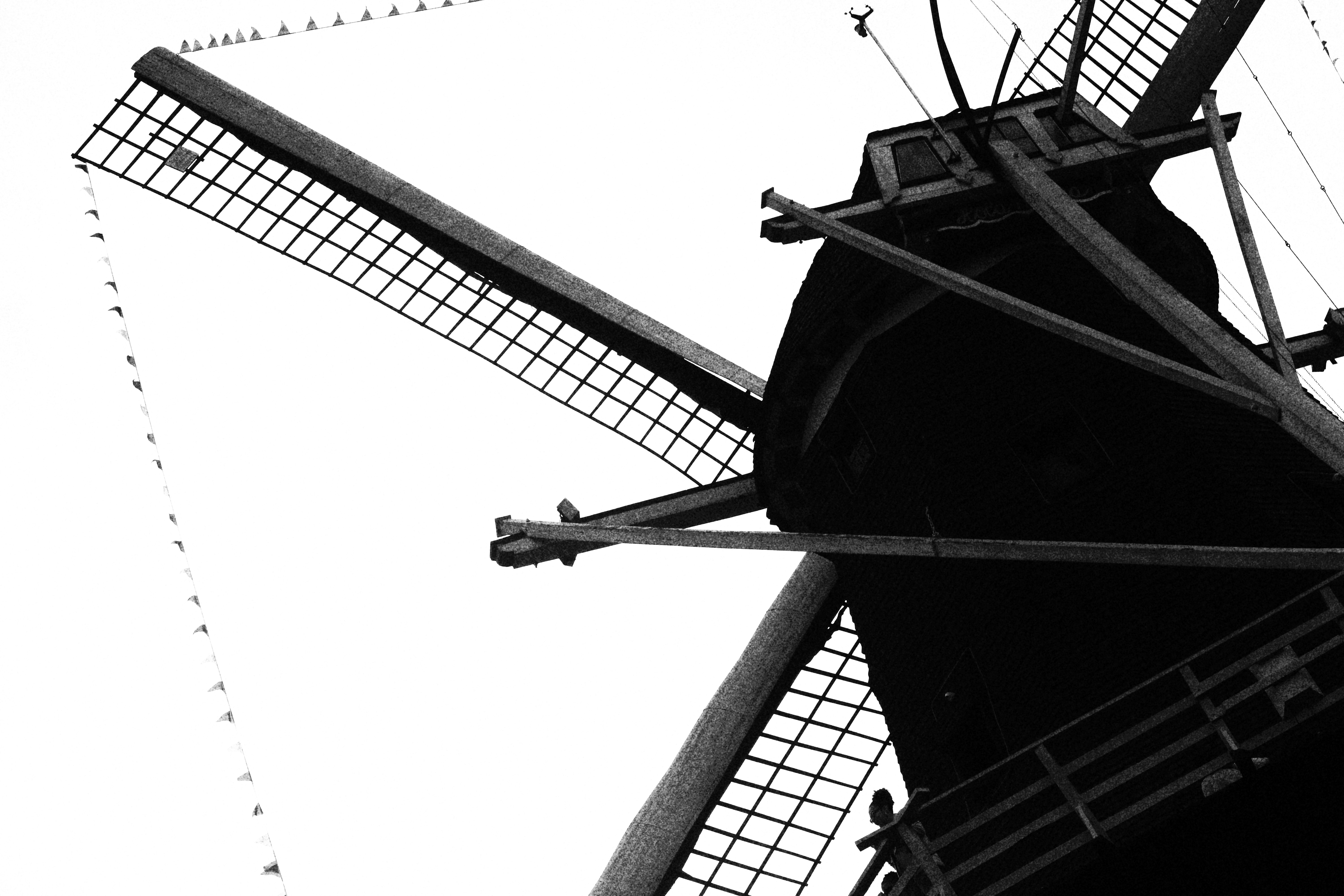 Monochrome Windmill Silhouette: Angled Giants Against the Sky