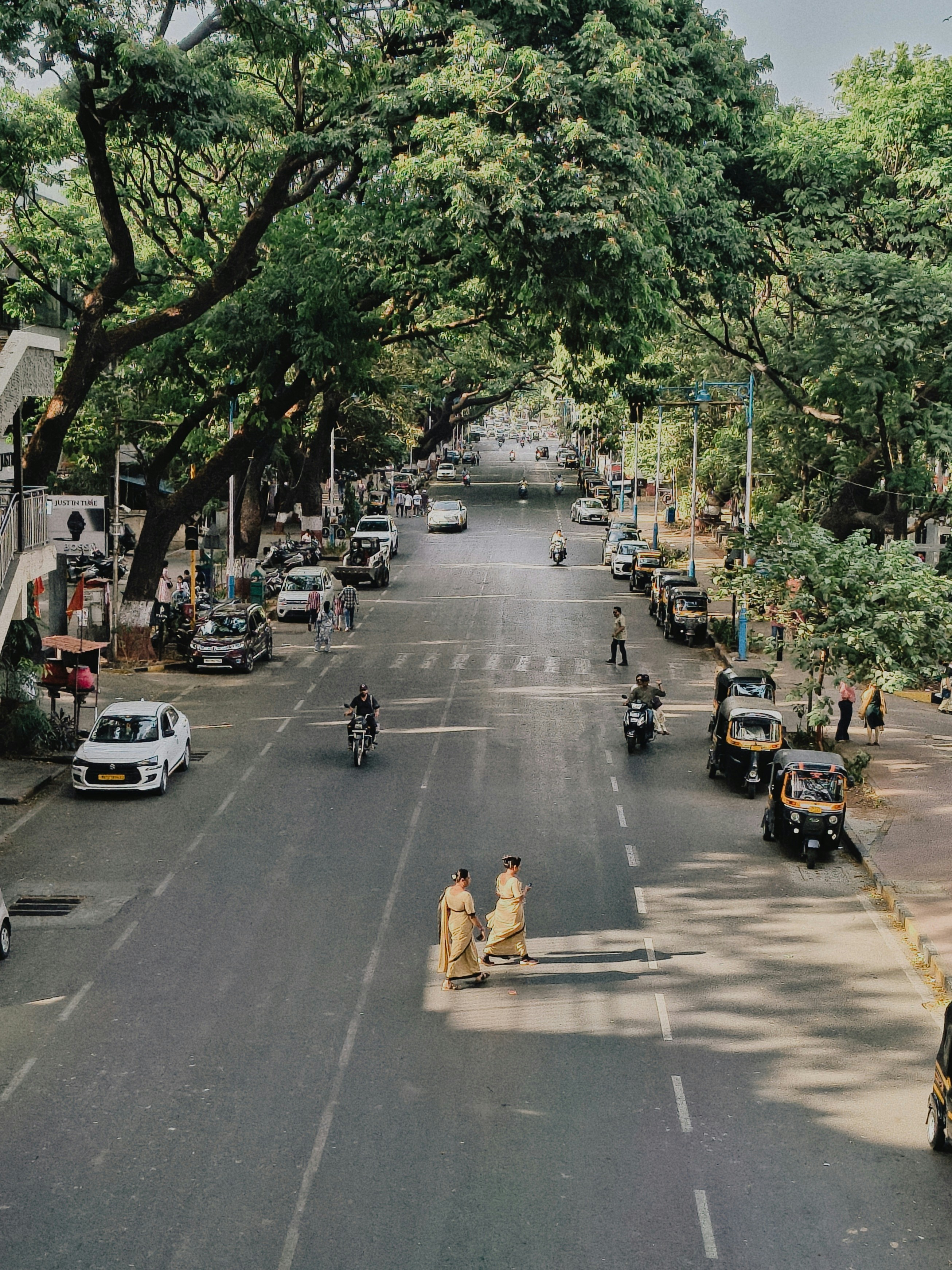 Crossing Moments: Two Pedestrians in the Center Lane of a Busy City Street