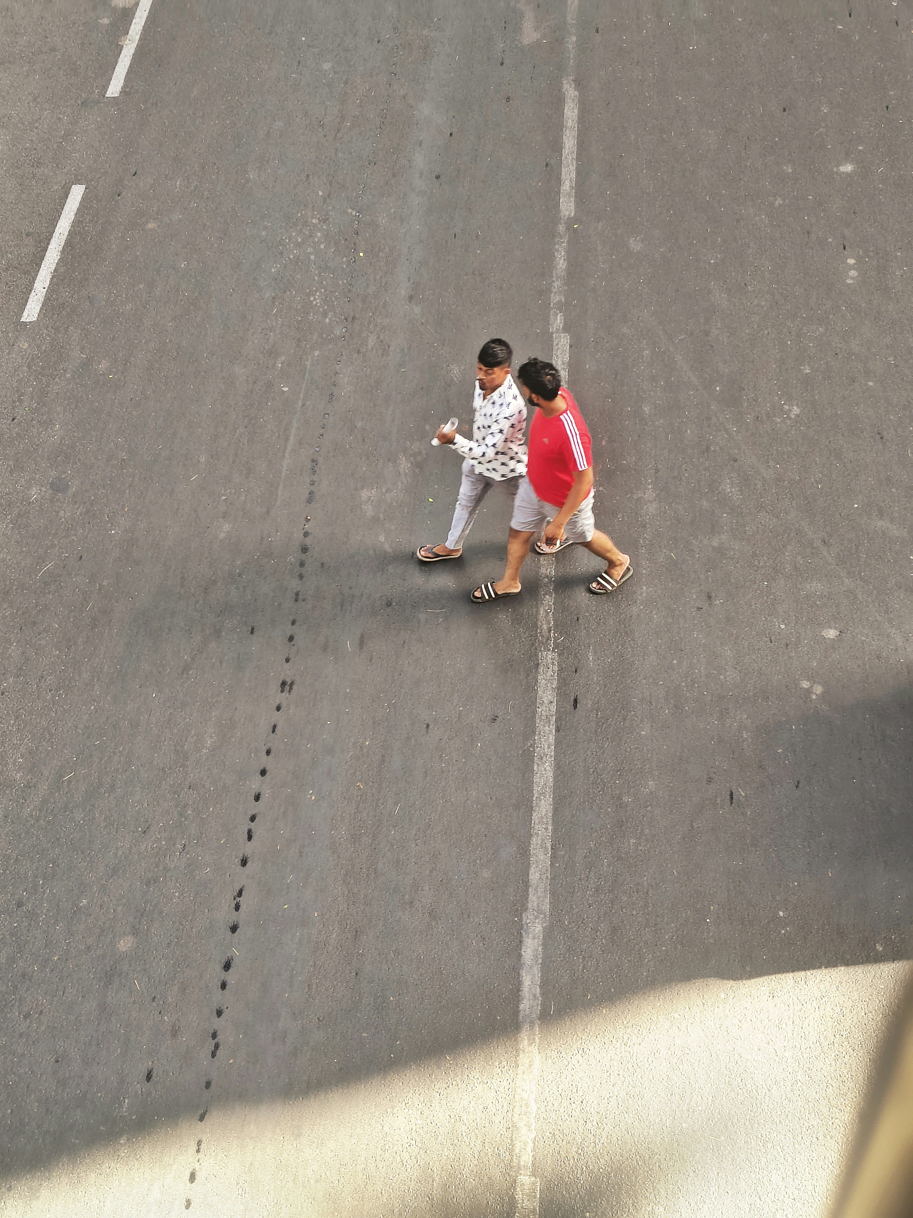 Midday Stroll: Aerial View of Friends Crossing the Marked Line