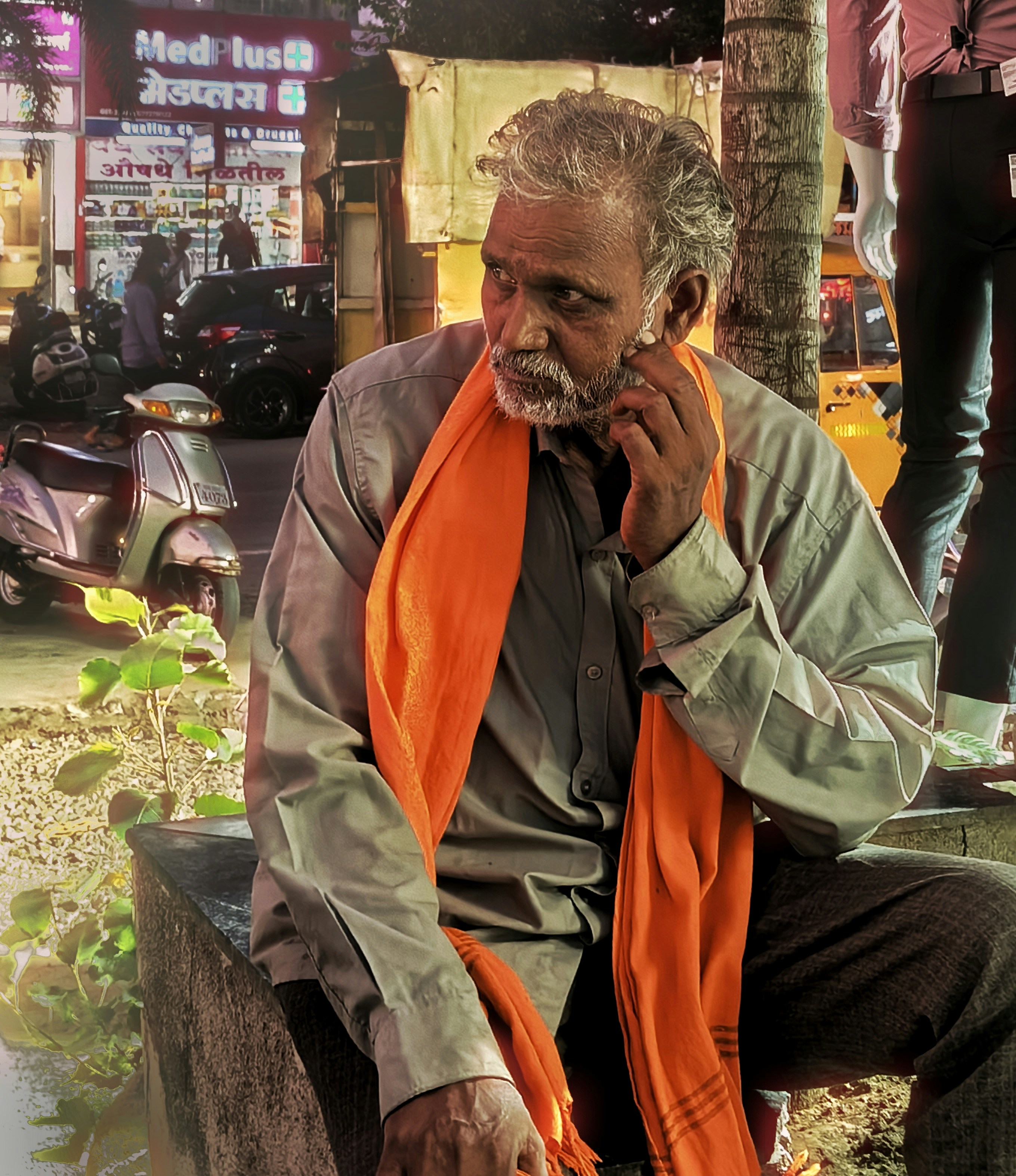 Self-reflection on a sunlit street: an elder man with orange scarf in thoughtful pose