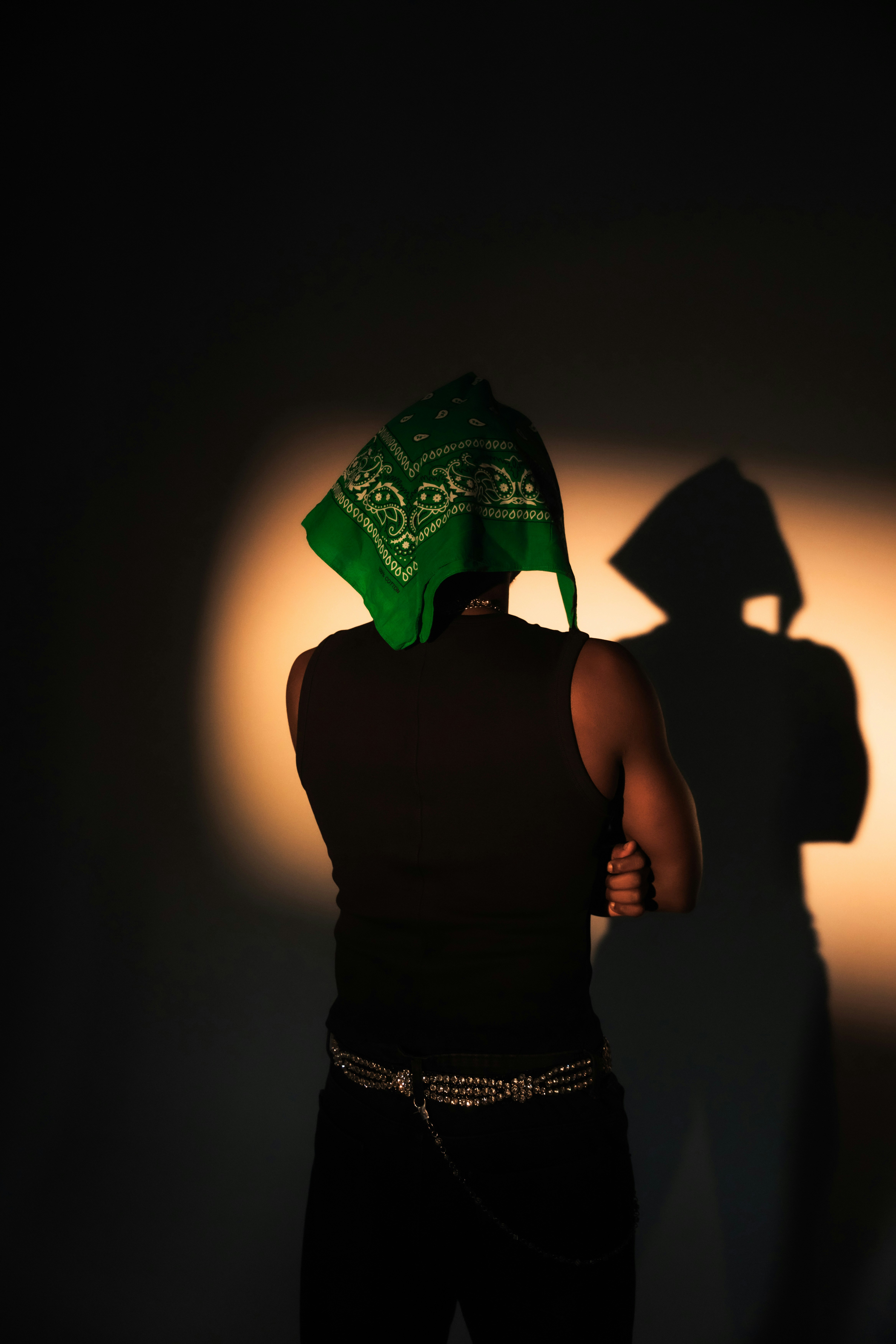 Shadows and Spotlight: Bandana-Clad Silhouette in a Circle of Light