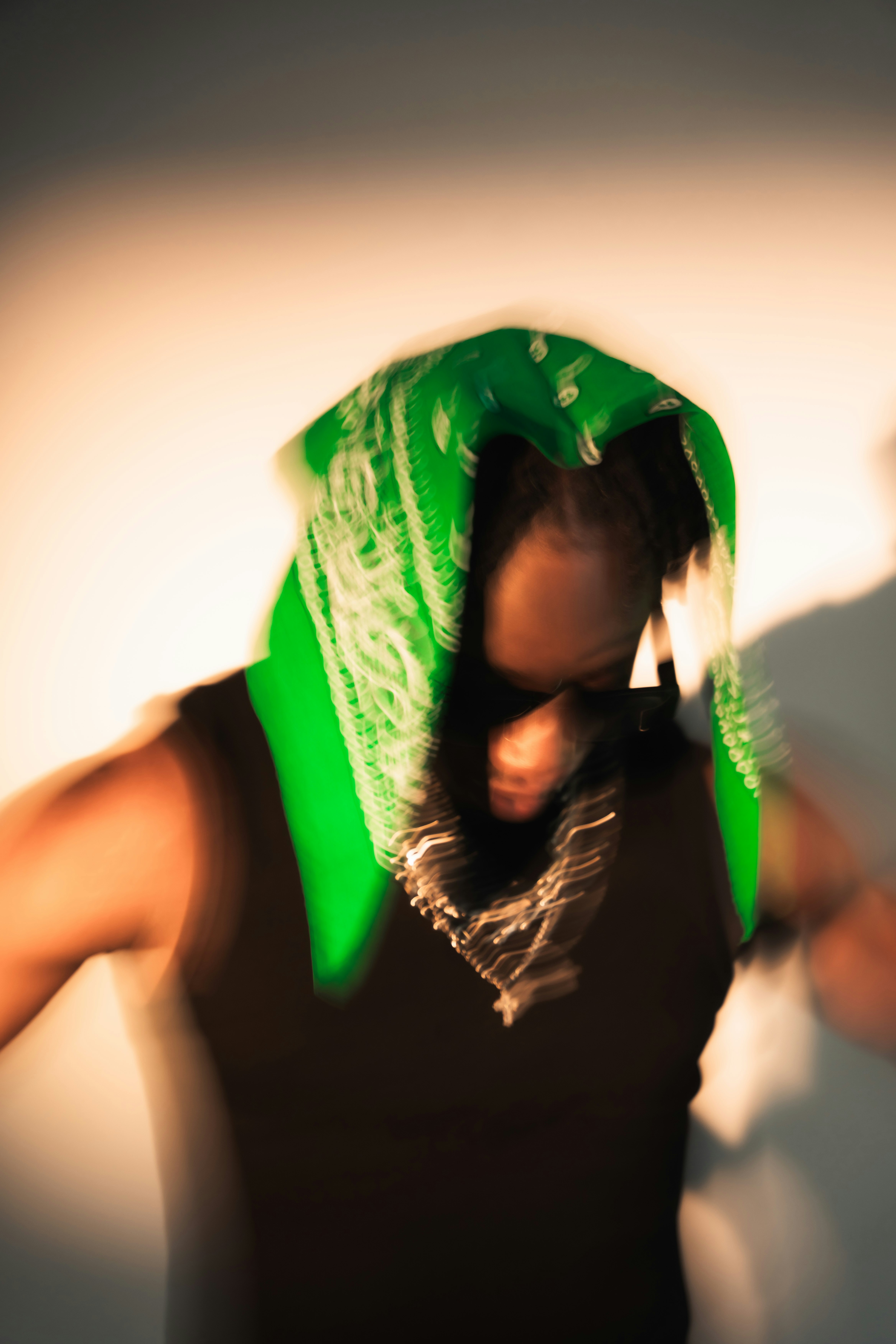 Green scarf, shadowed face: a motion-blurred portrait in motion