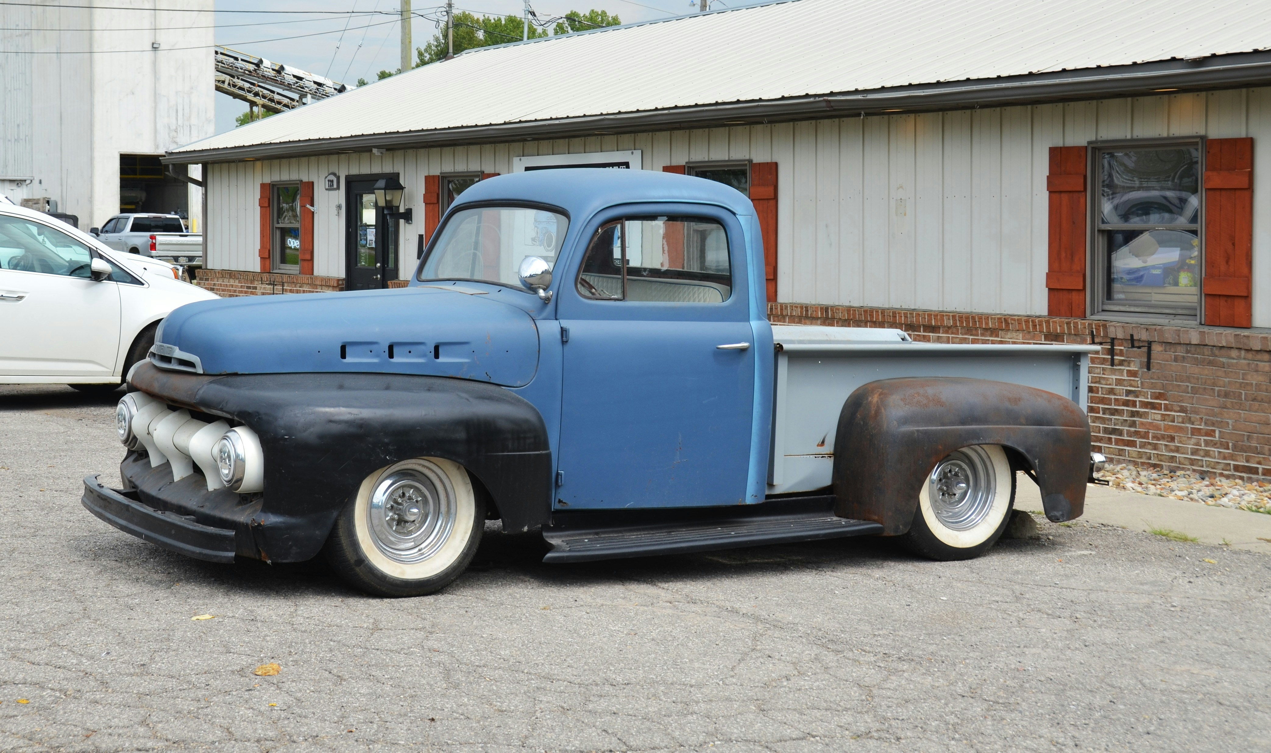 Blue Vintage Pickup Resting by a Quiet Brick Building