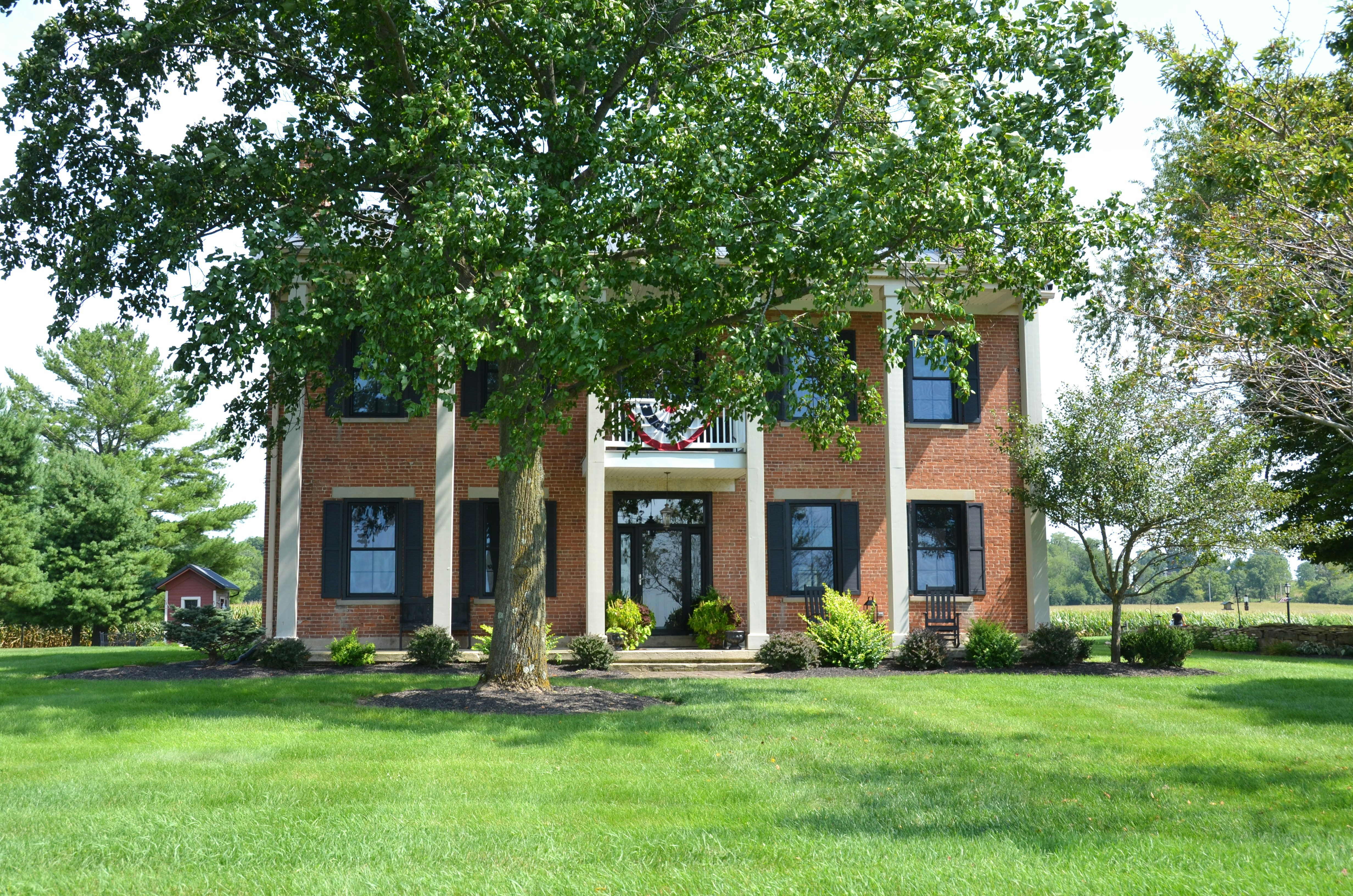 Brick House with Shaded Lawn and Central Entrance