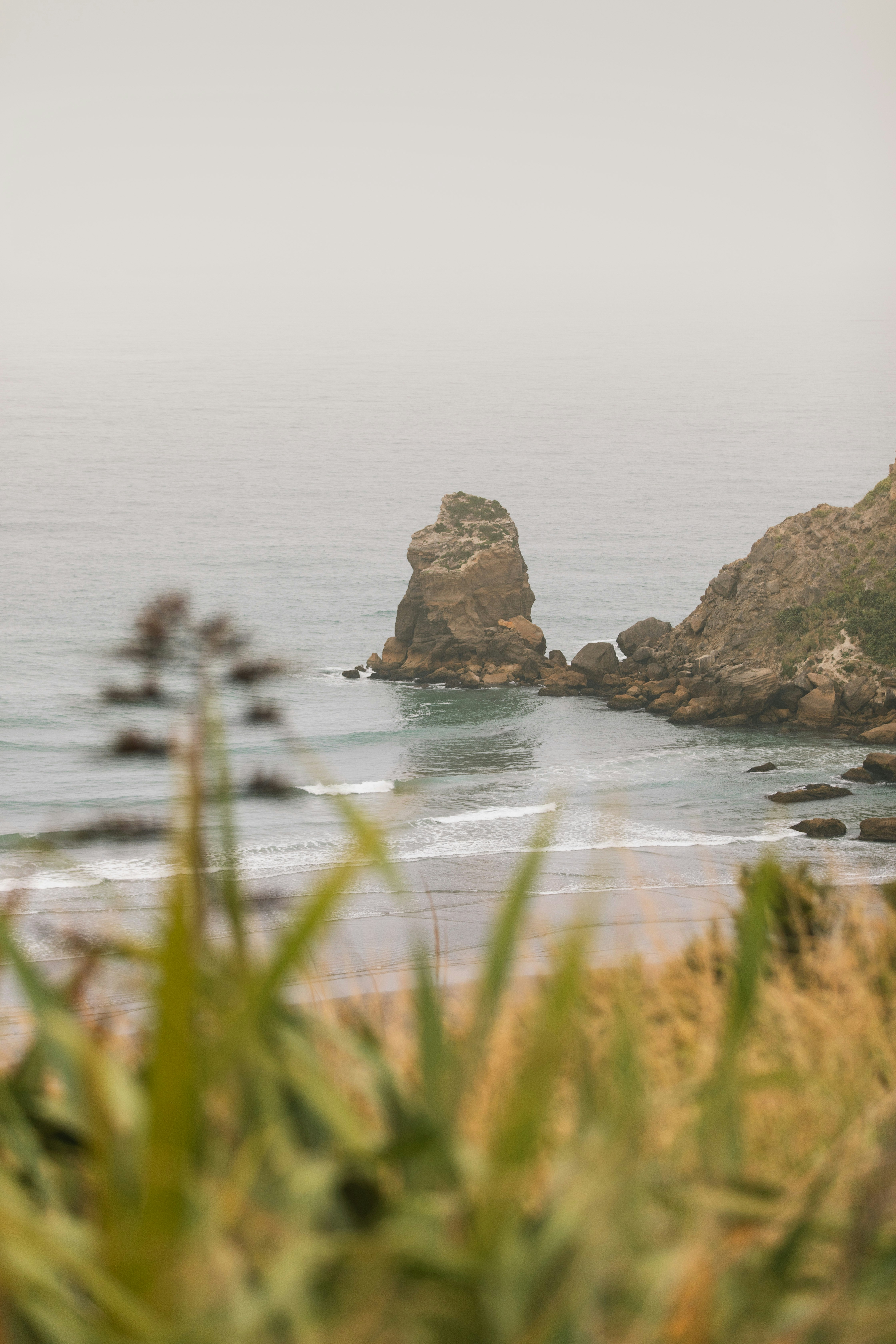 Sea Stack Silence: Coastal Rocks Framed by Blurred Beach Grass