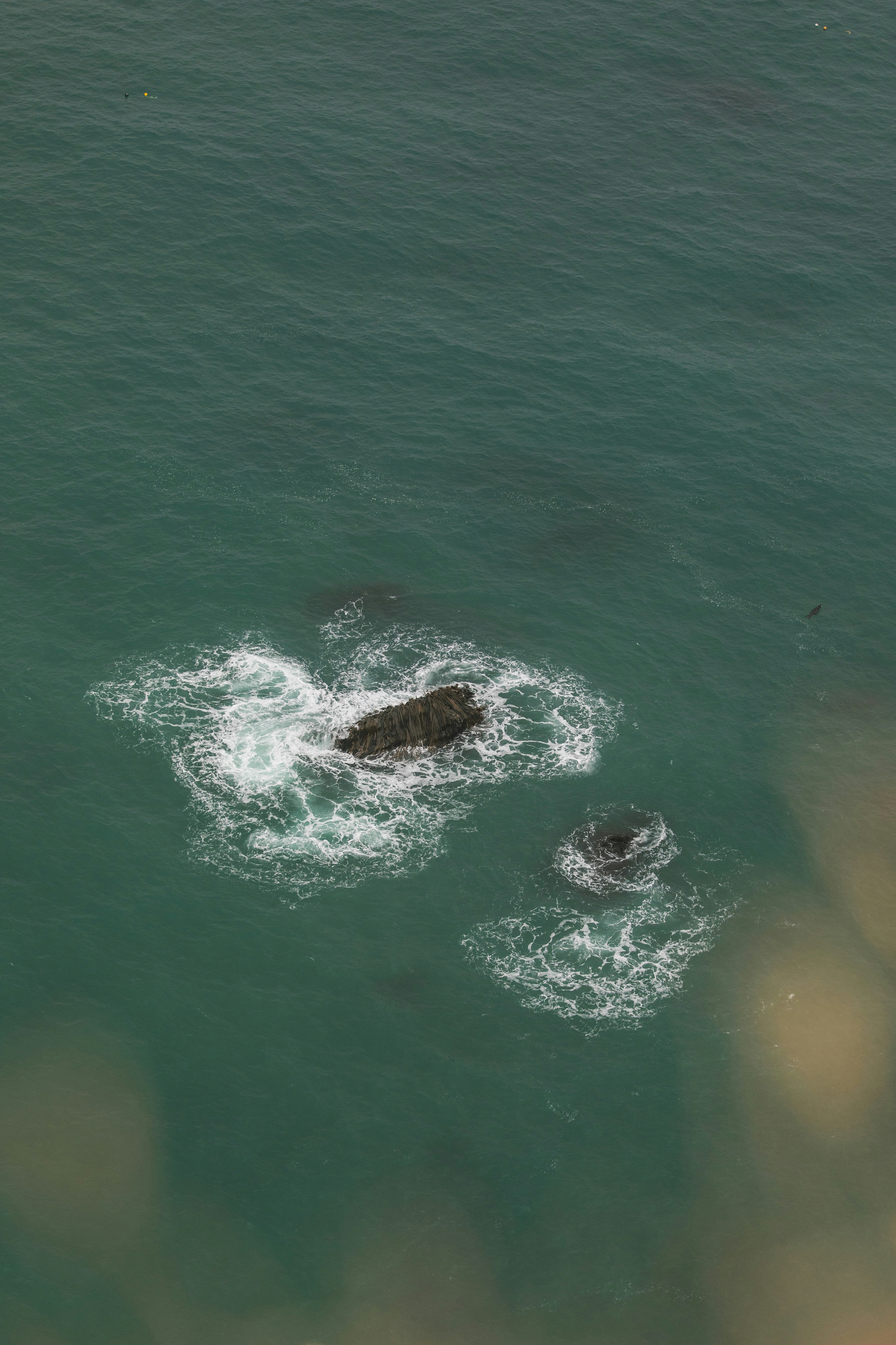 Rogue Rock in teal tides: an aerial encounter