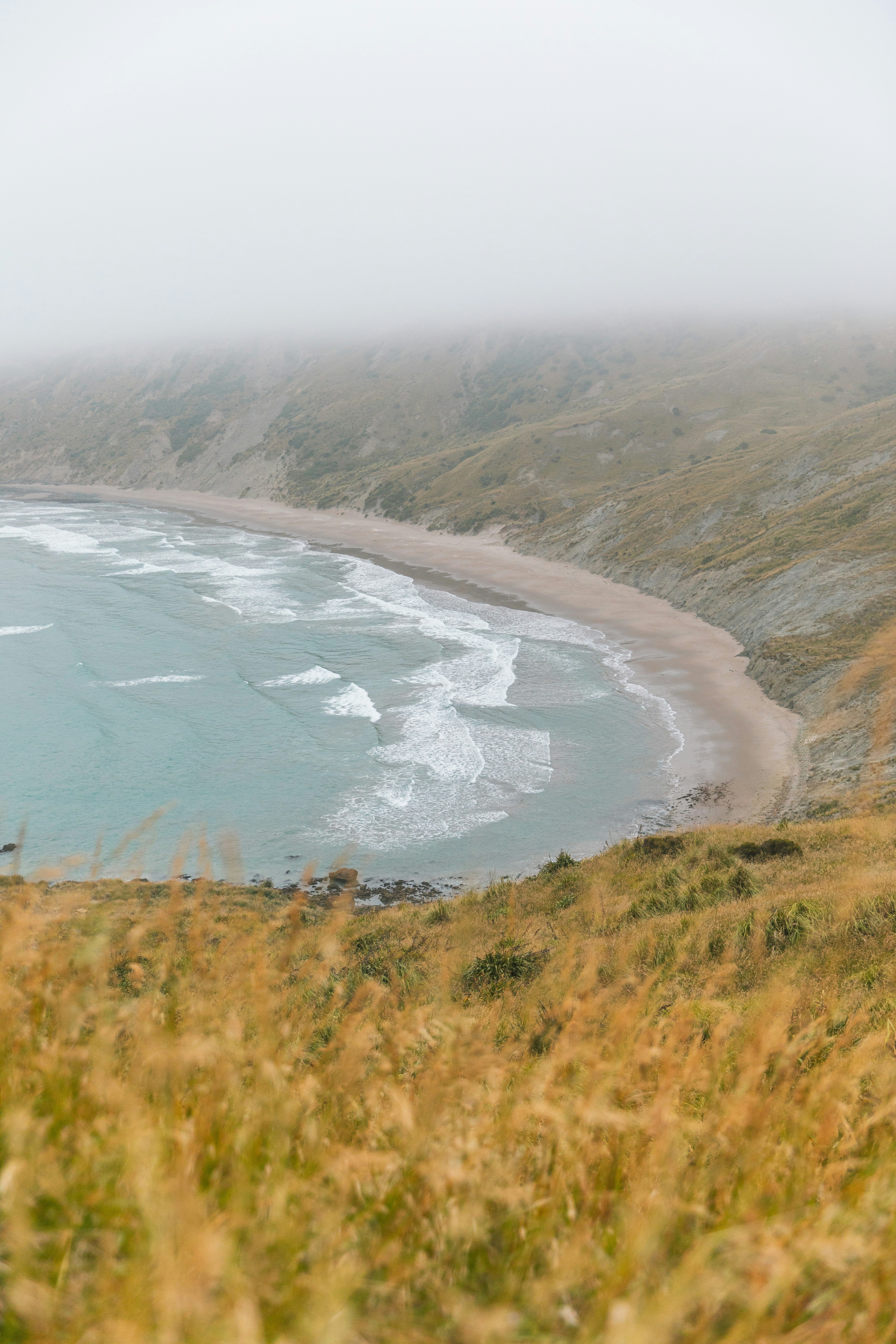 Coastal Cliff Vista: A Misty Dawn Over Turbulent Waves