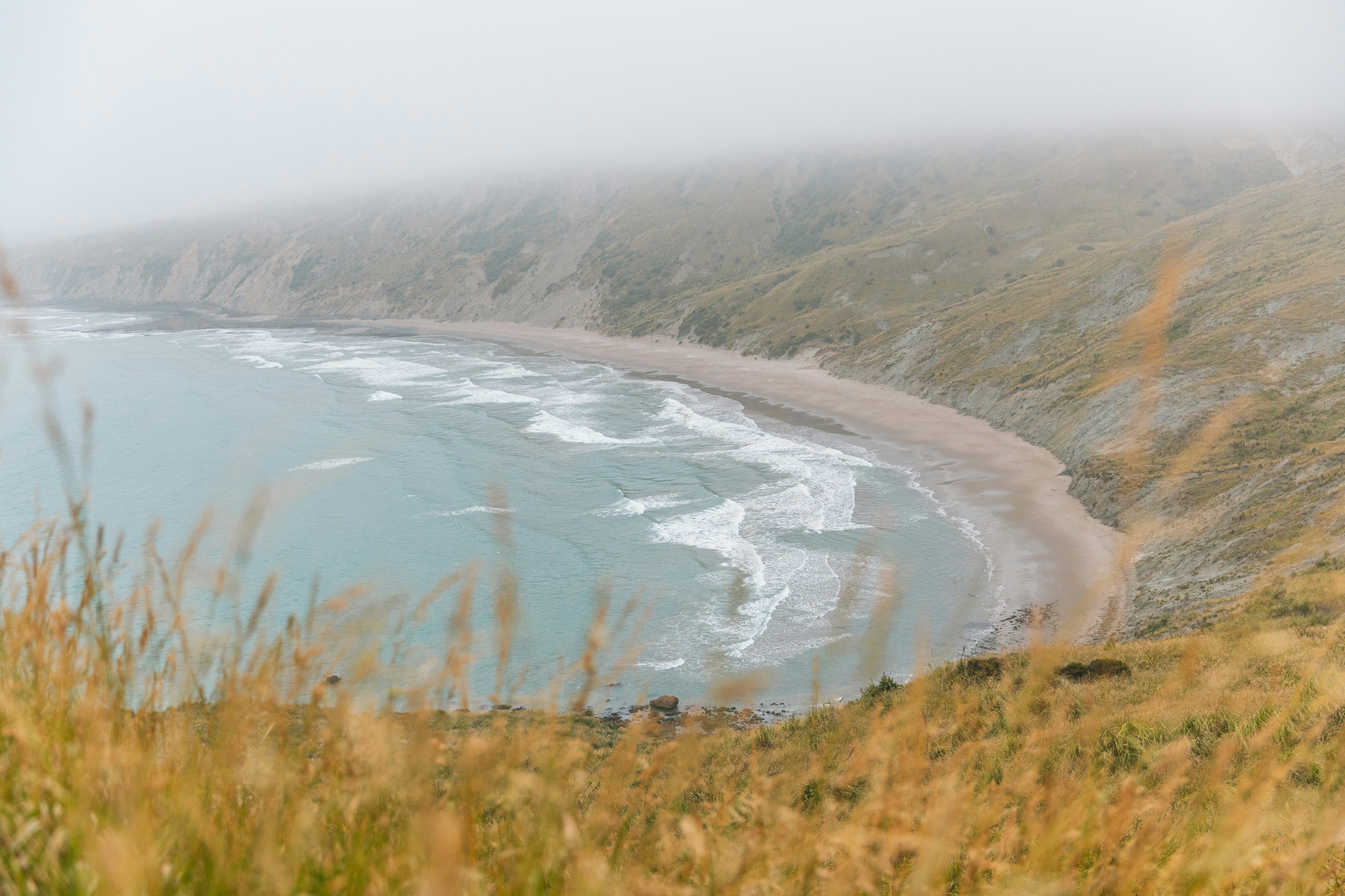 Hidden Cove Ashore: Waves Brush a Golden Cliff