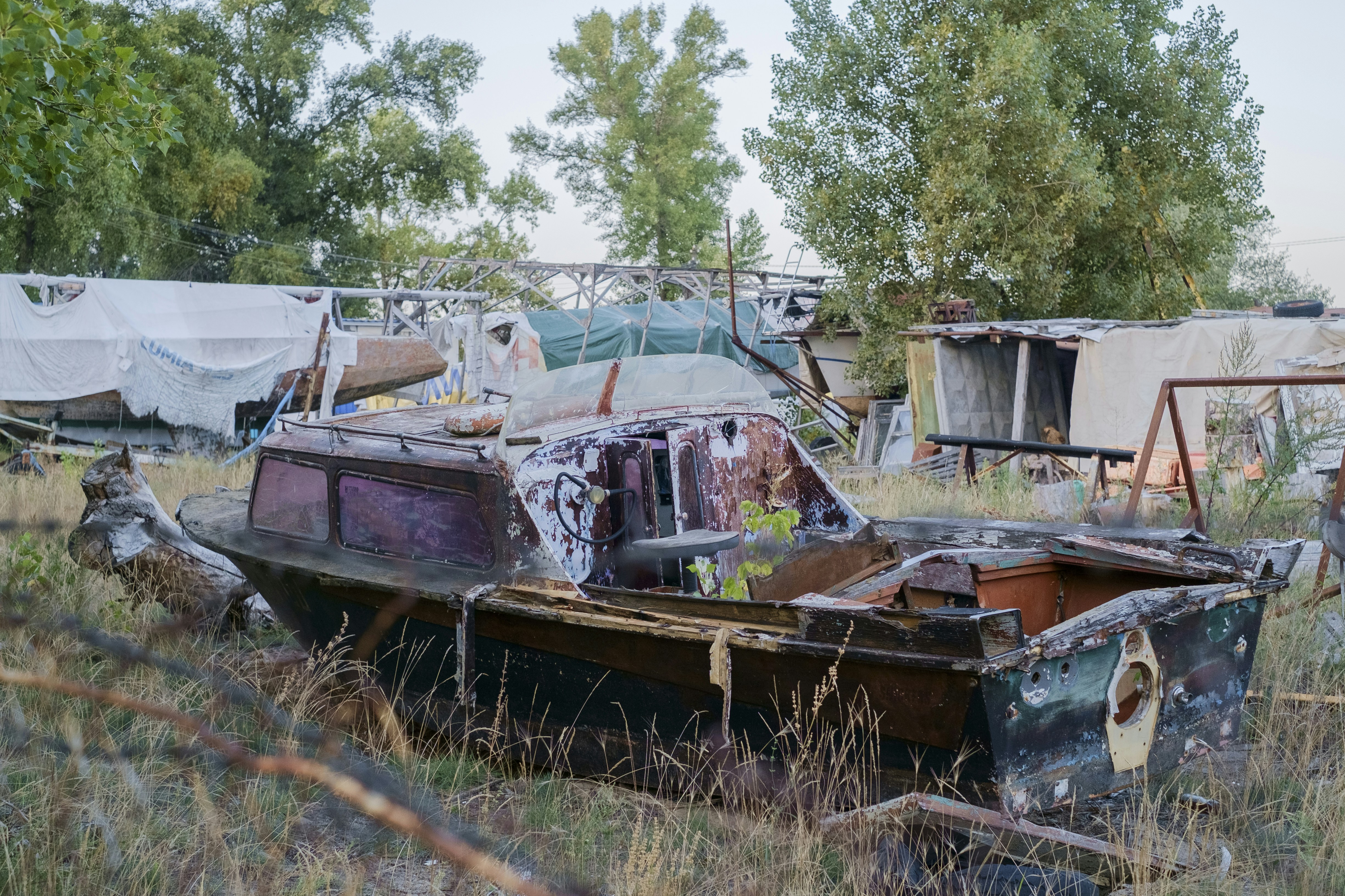 Deserted Rust: an old boat among a makeshift harbor of tents