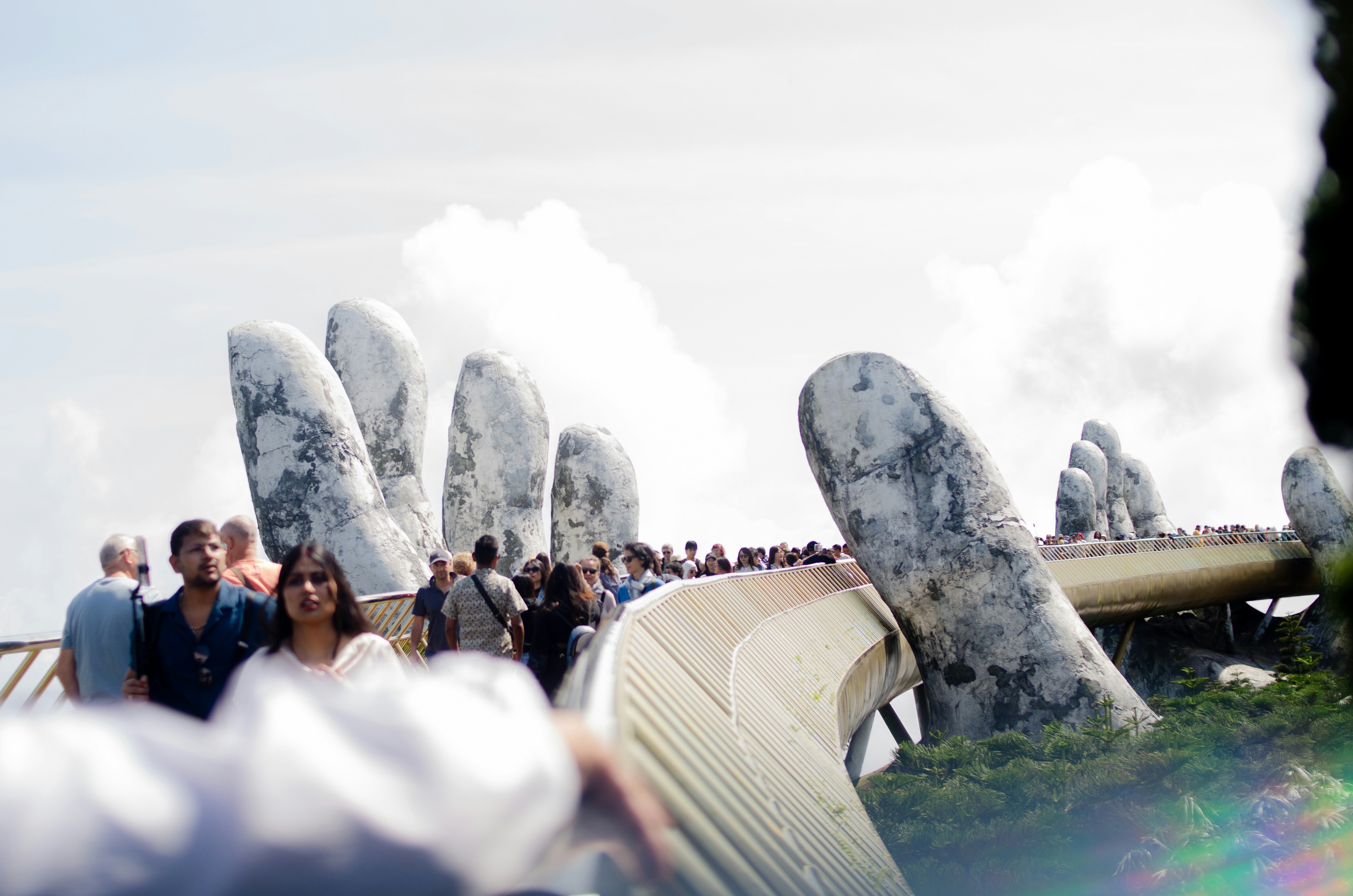 Crowd on a Curved Walkway Beside Monumental Sculptures