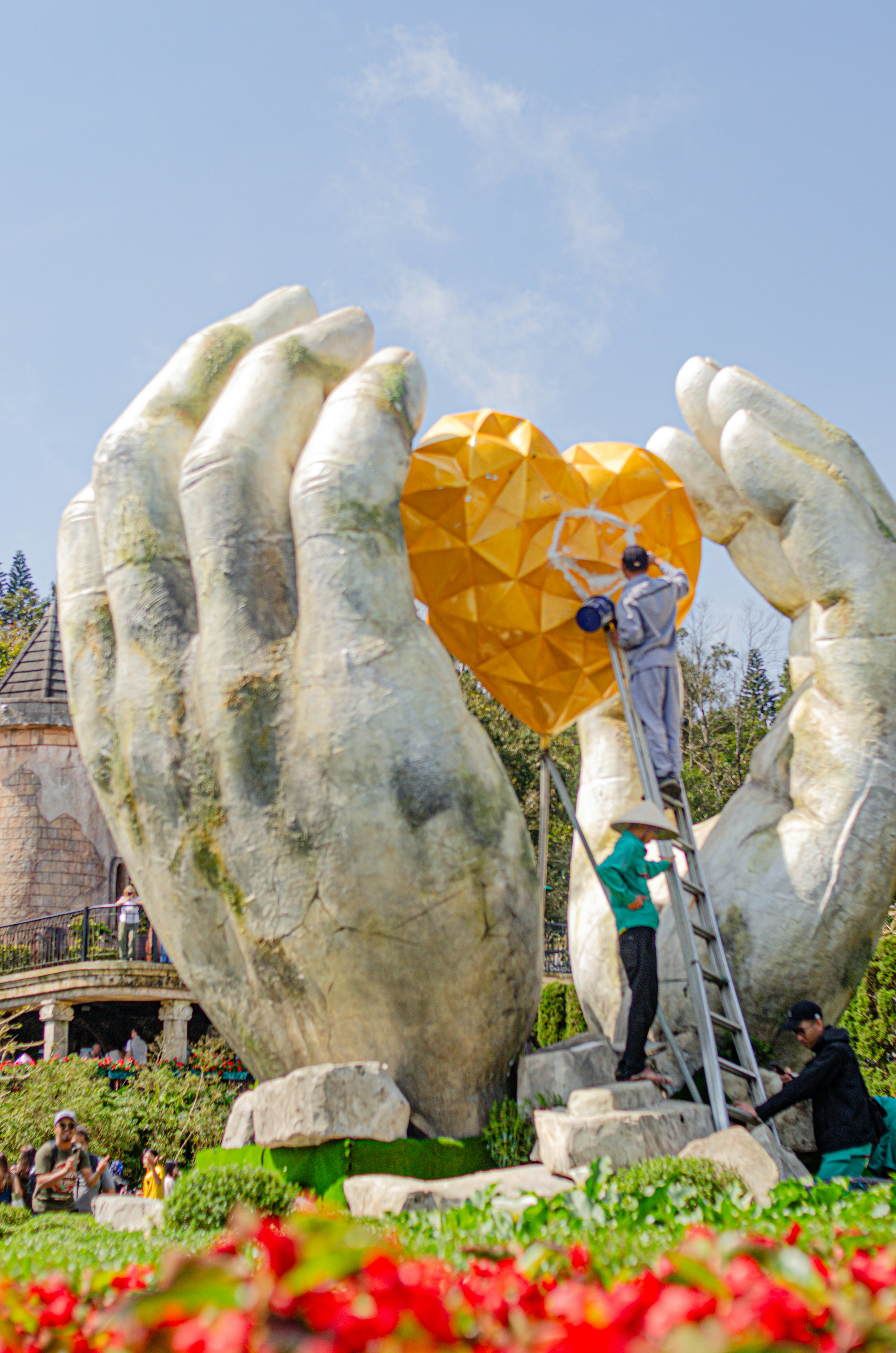Heart of Hands: Sculpted Giants Framing a Bright Geometric Heart