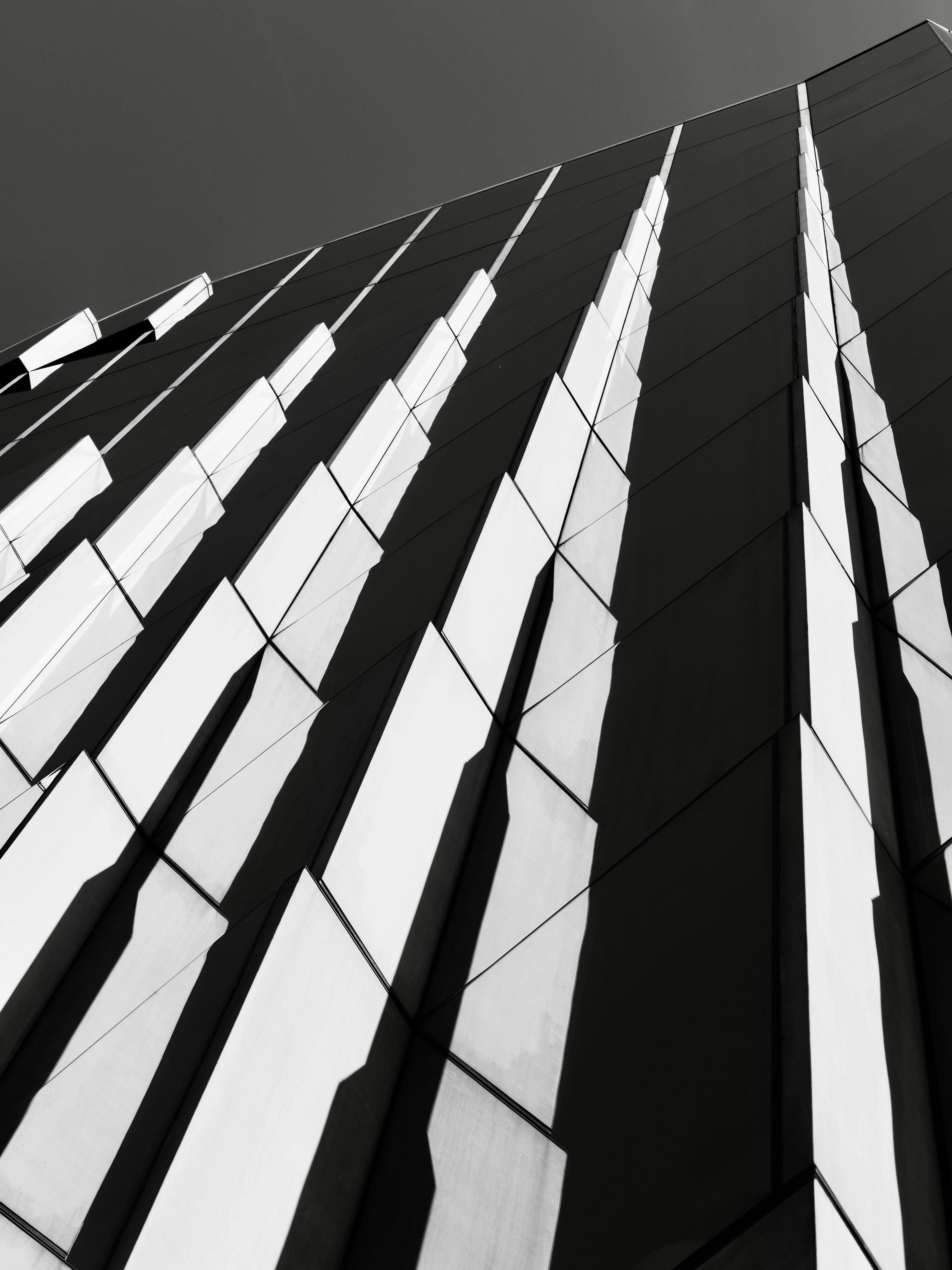 Monochrome Facade: Repeating Strata Against a Growing Sky
