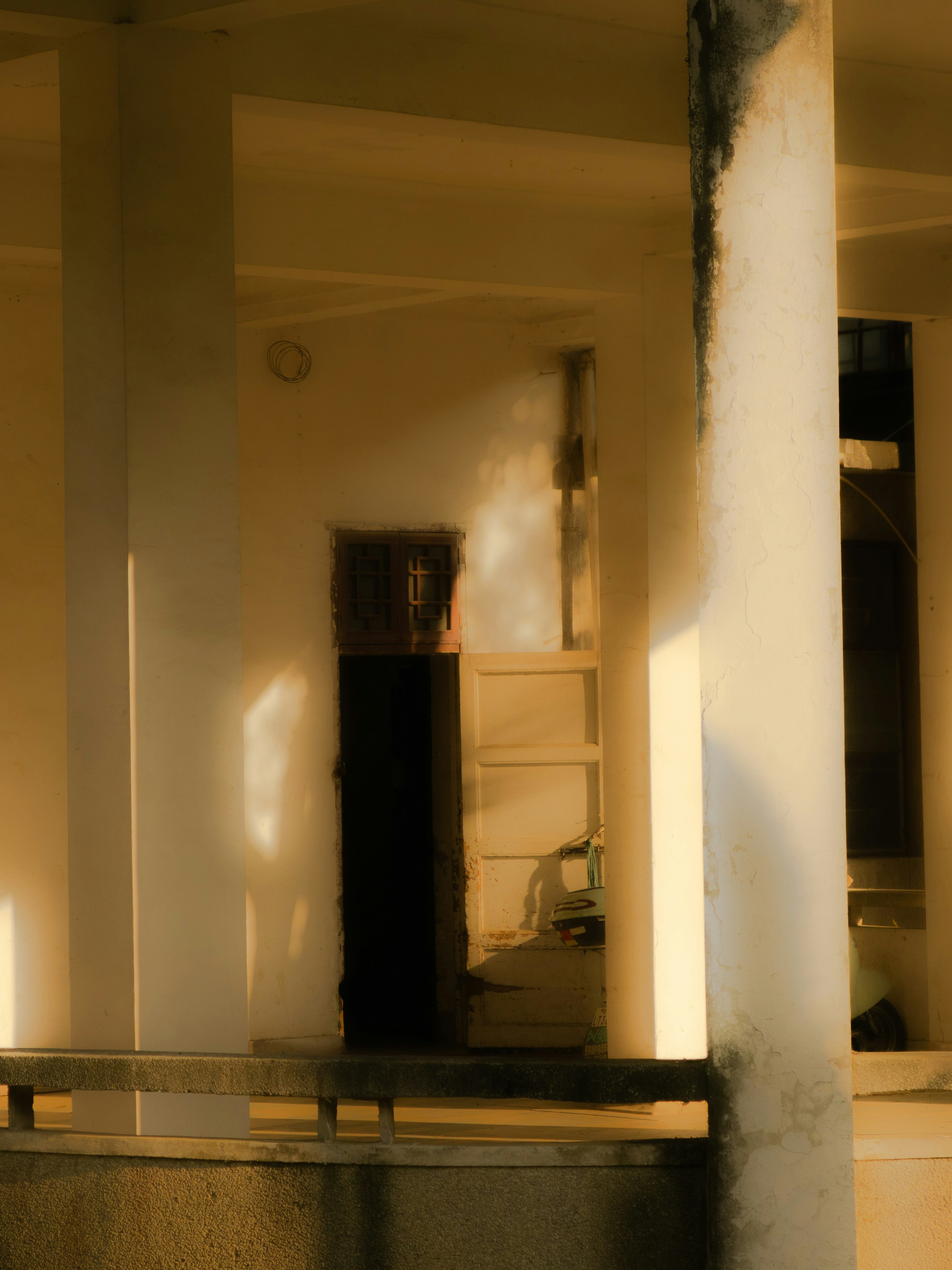 Sunlit Columns and Shadows: An Abandoned Corridor Bathed in Warm Hue