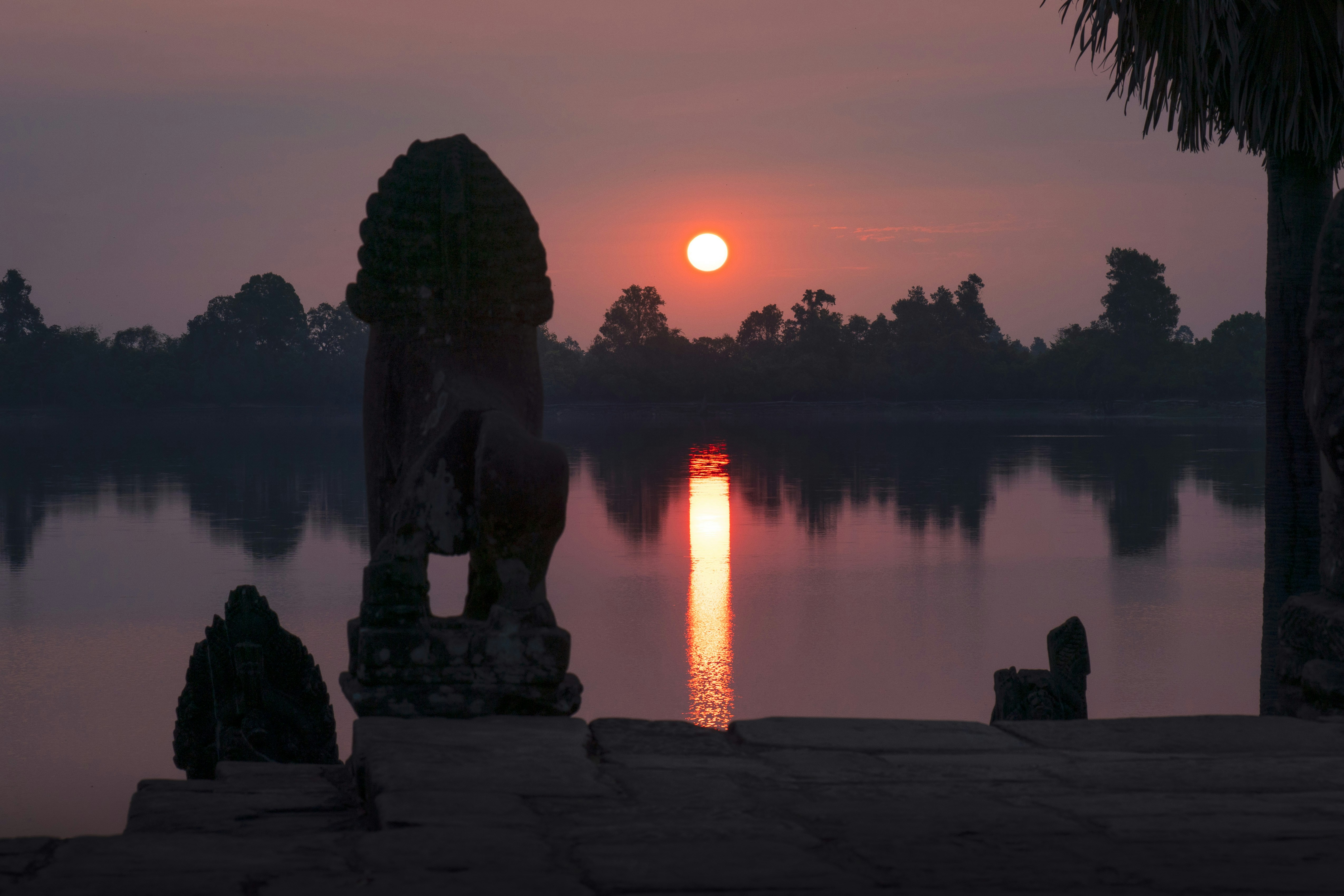 Silhouette of a guardian at sunset over a tranquil river