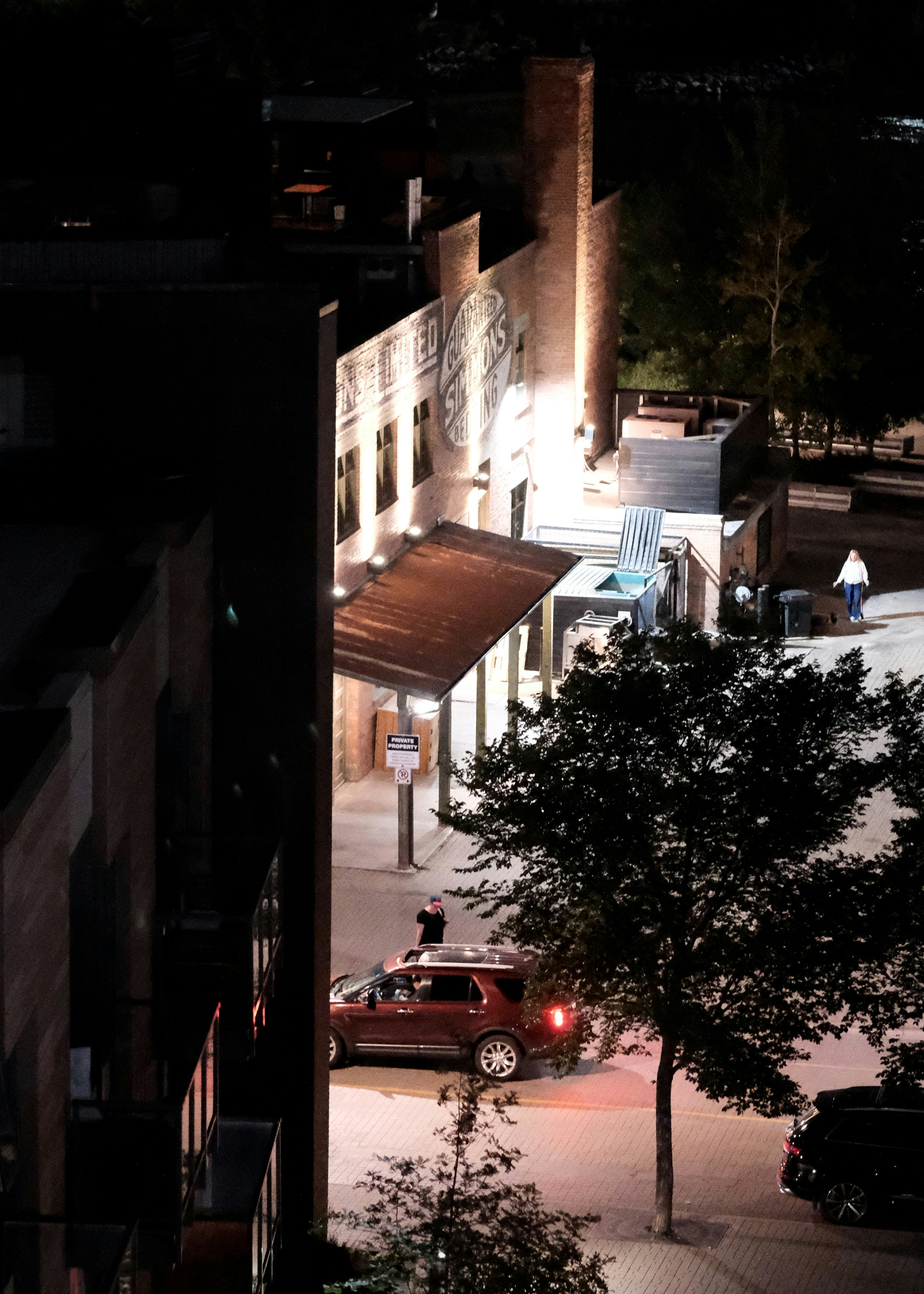Night Alleyway Spotlight: A Quiet Urban Moment by the Brick Facade