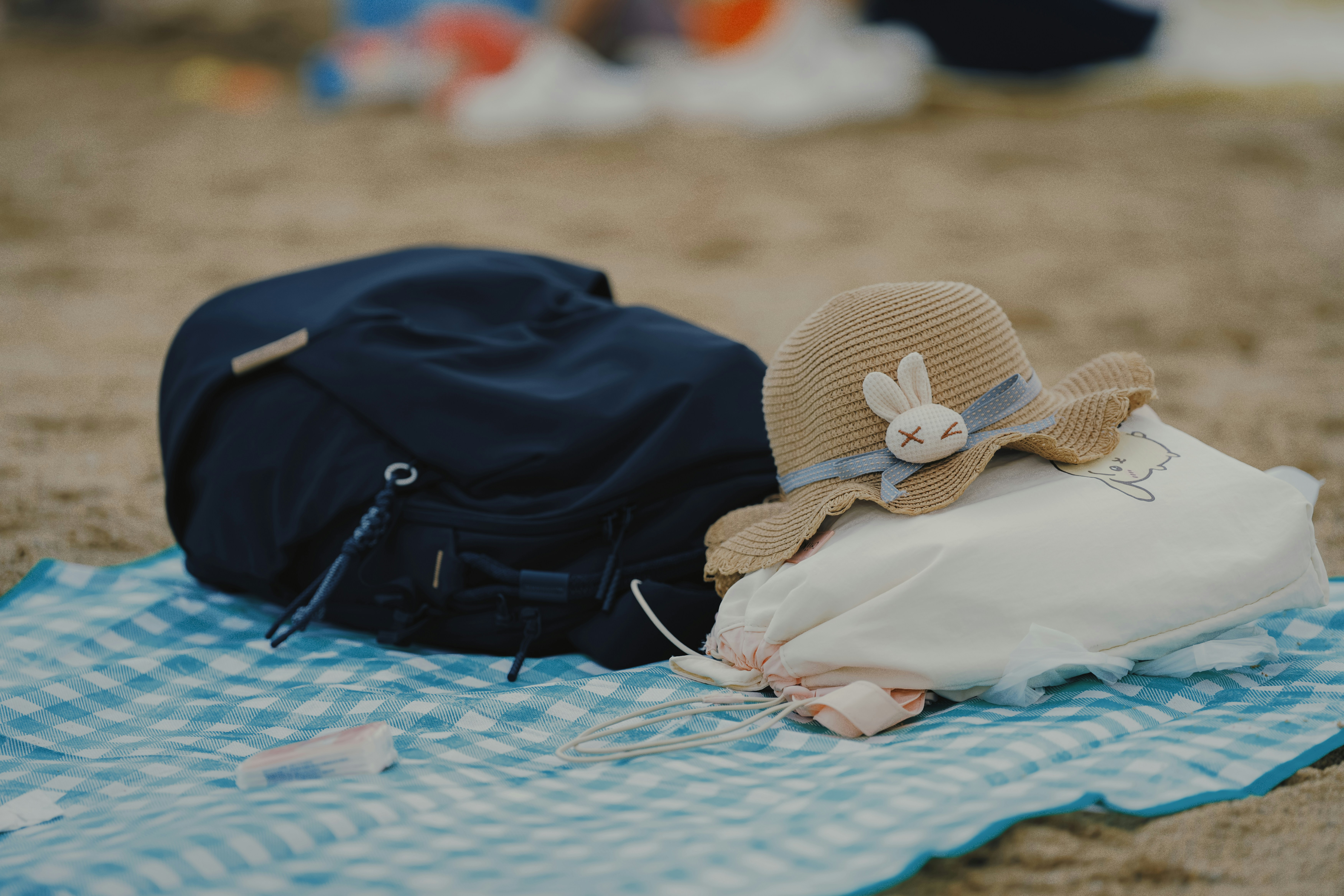 Resting on the Fabric: A Quiet Beach Scene with a Straw Hat