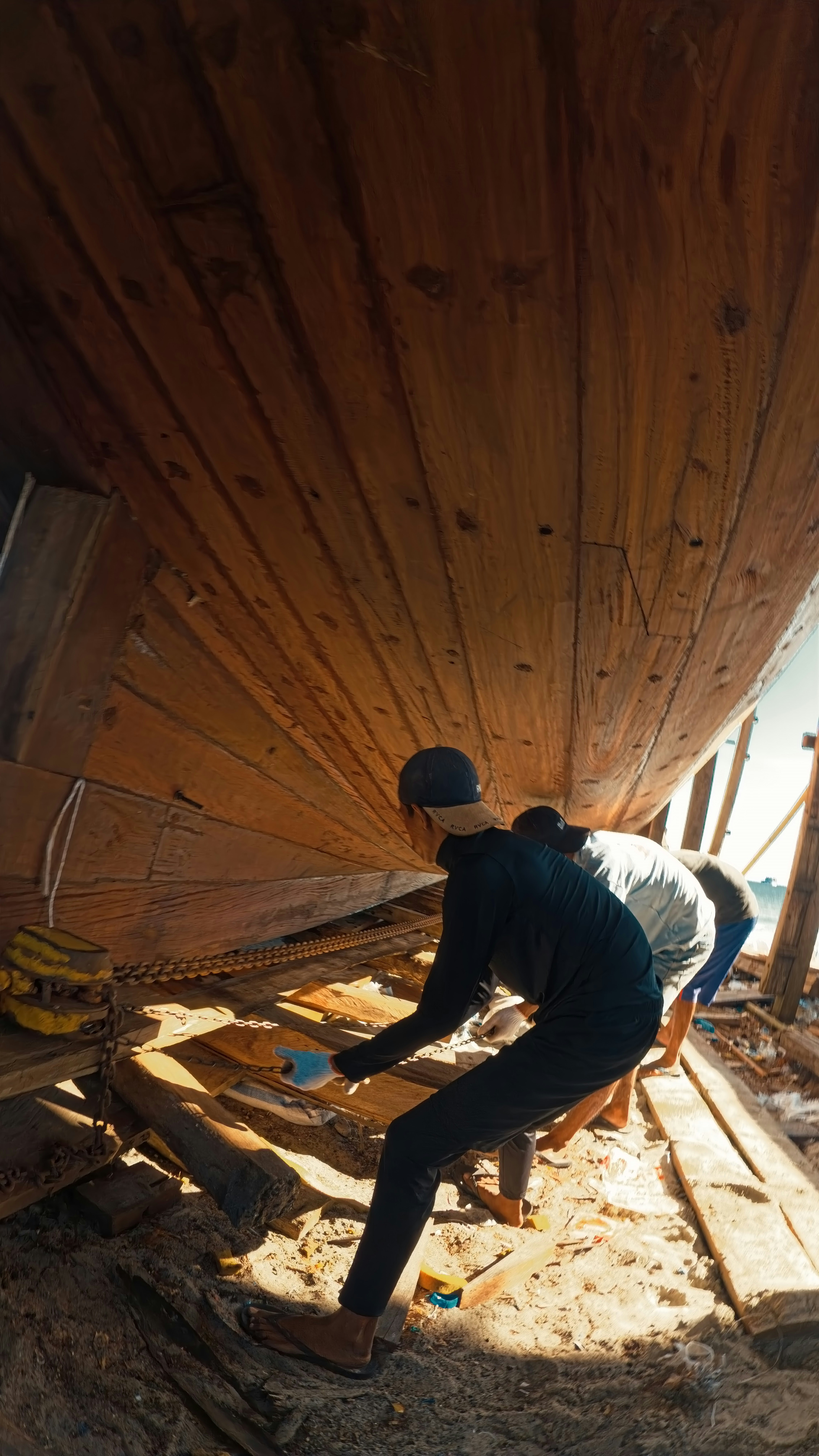 Crewman at the Bow: Workmen Aligning a Vessel Under Construction