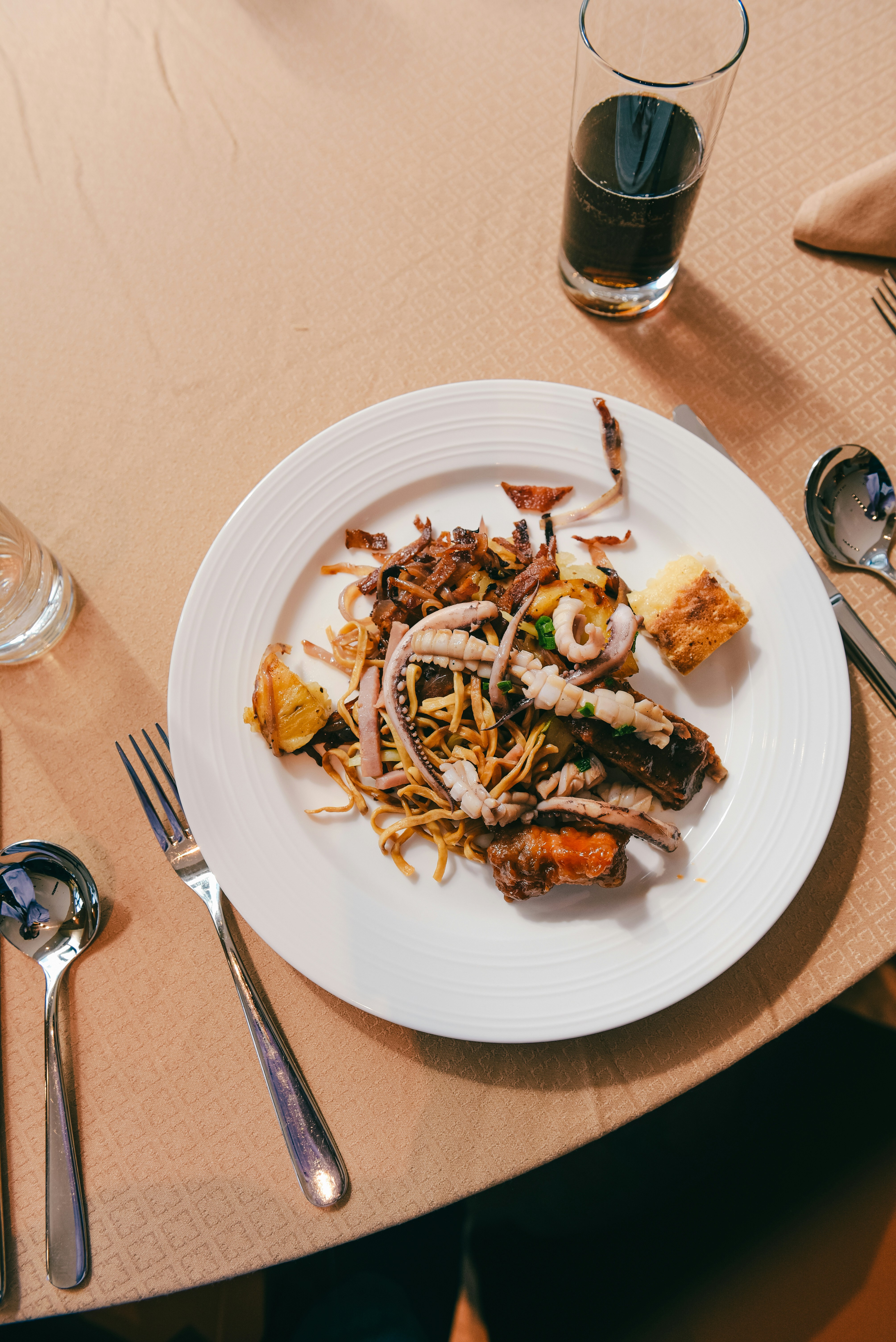 Plate of mixed seafood pasta at a sunlit table