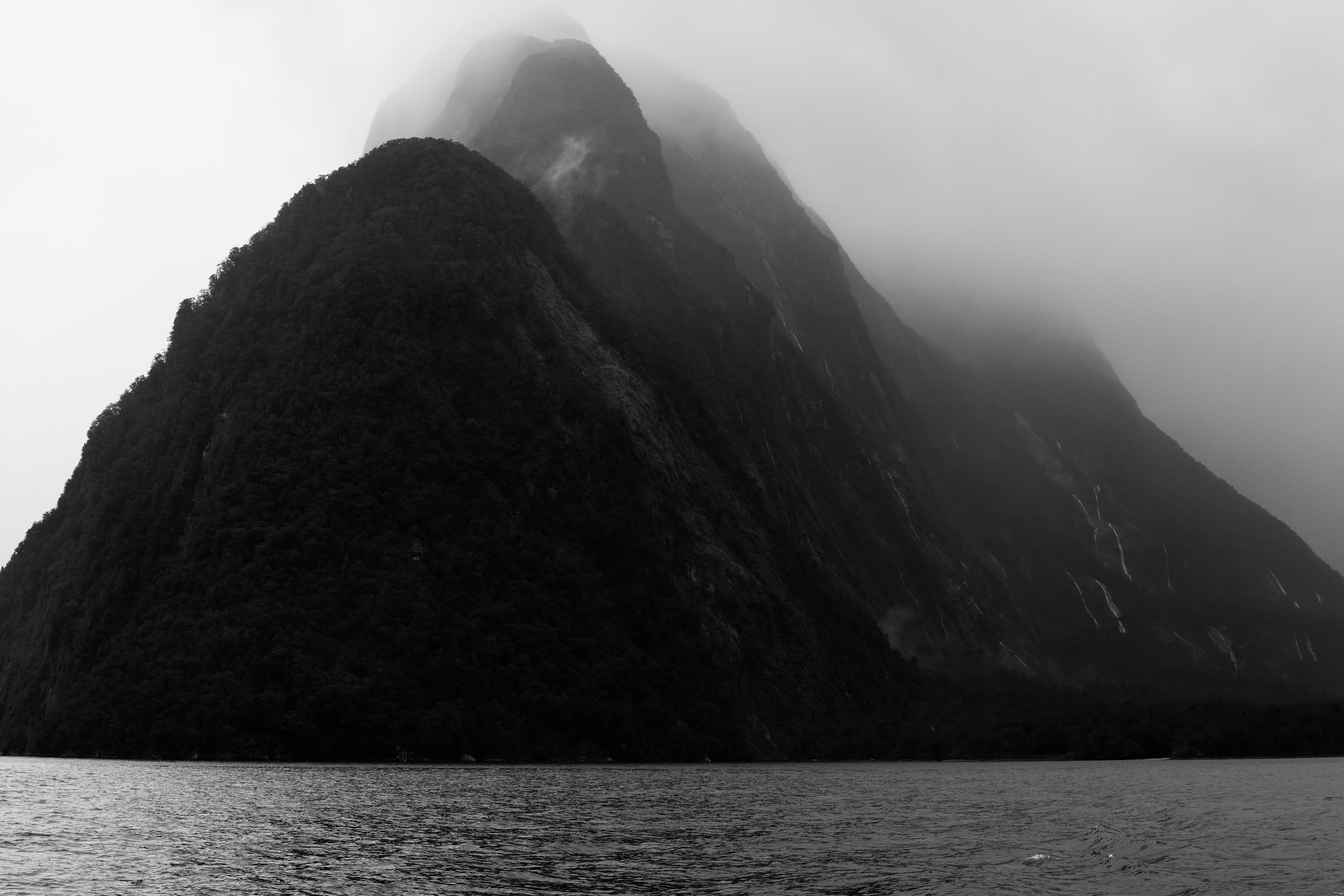 Mist-Wrapped Peak Over Quiet Fjord