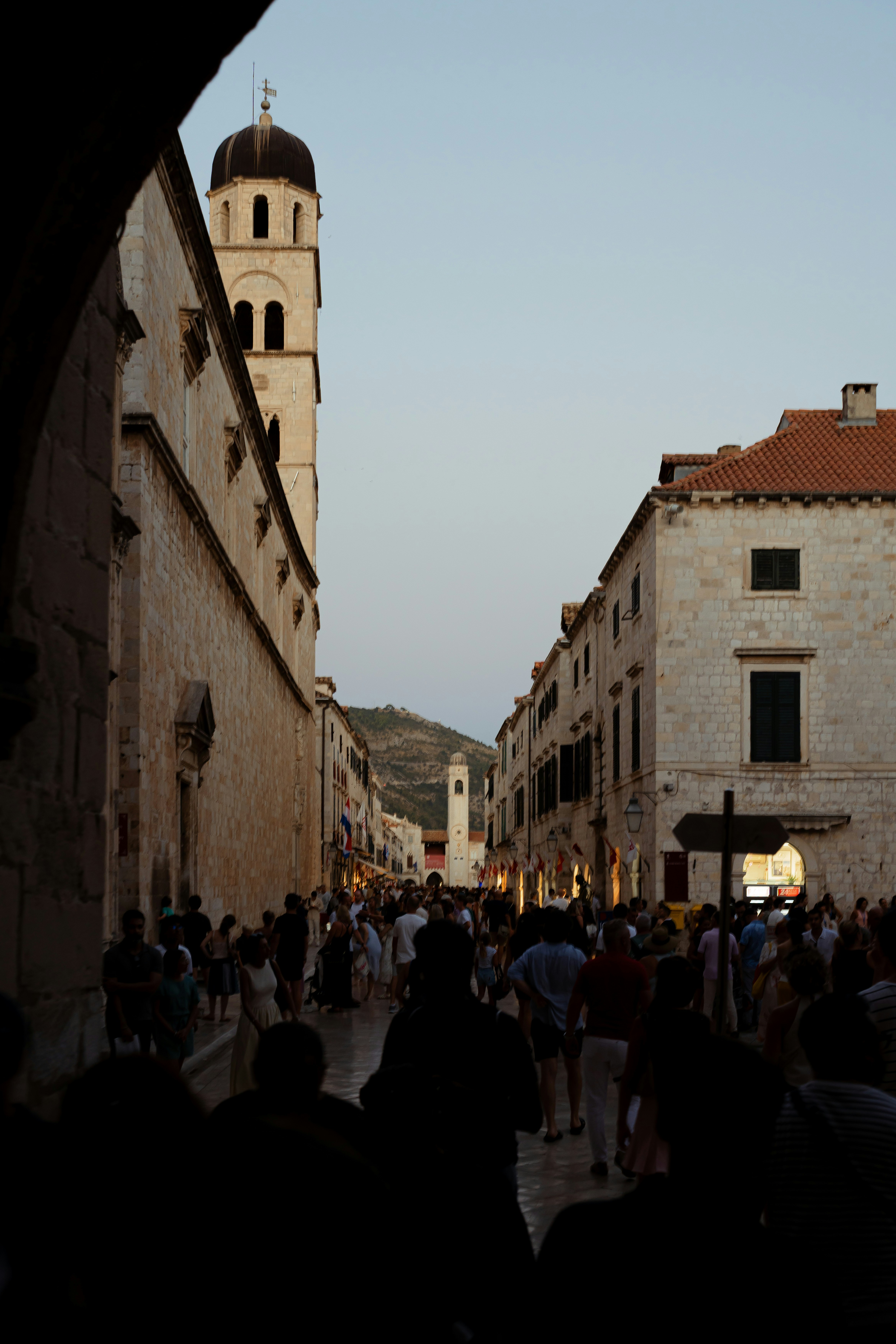 Cobbled Street Beneath an Ancient Tower at Sunset