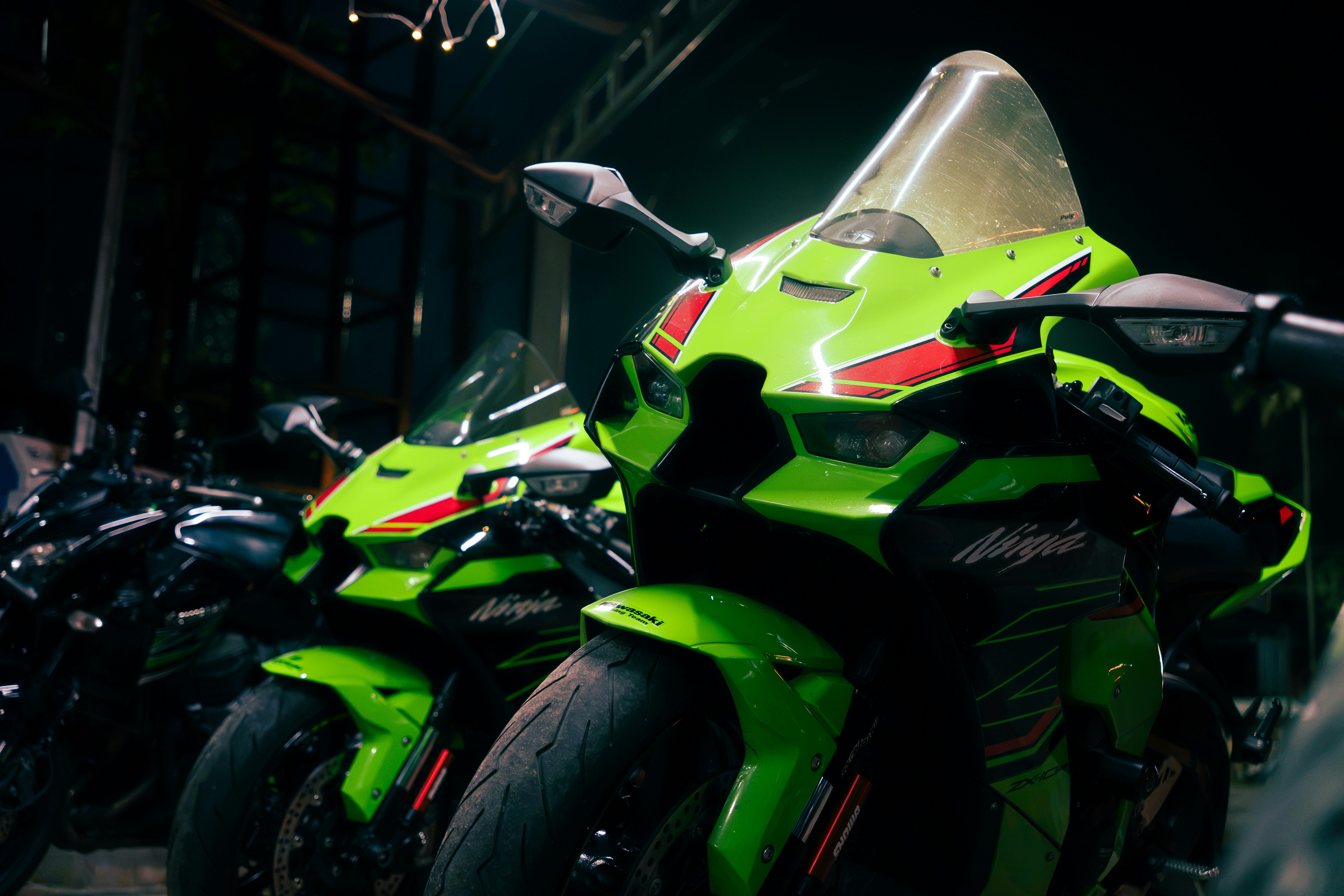 Green Thunder: Row of Kawasaki Ninjas in a Dim Workshop