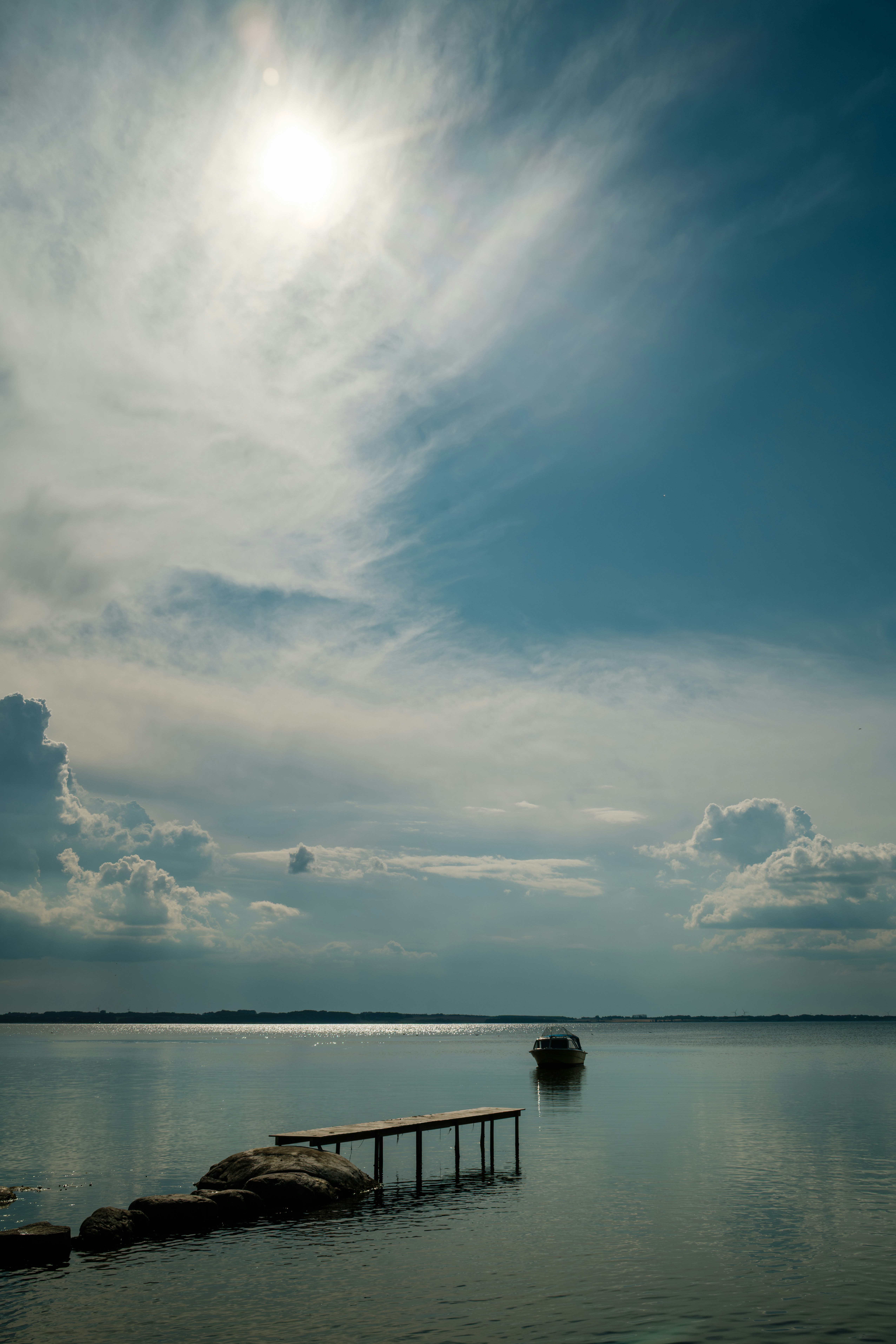 Quiet Horizon: A Boat Resting by a Pier Under Quiet Skies