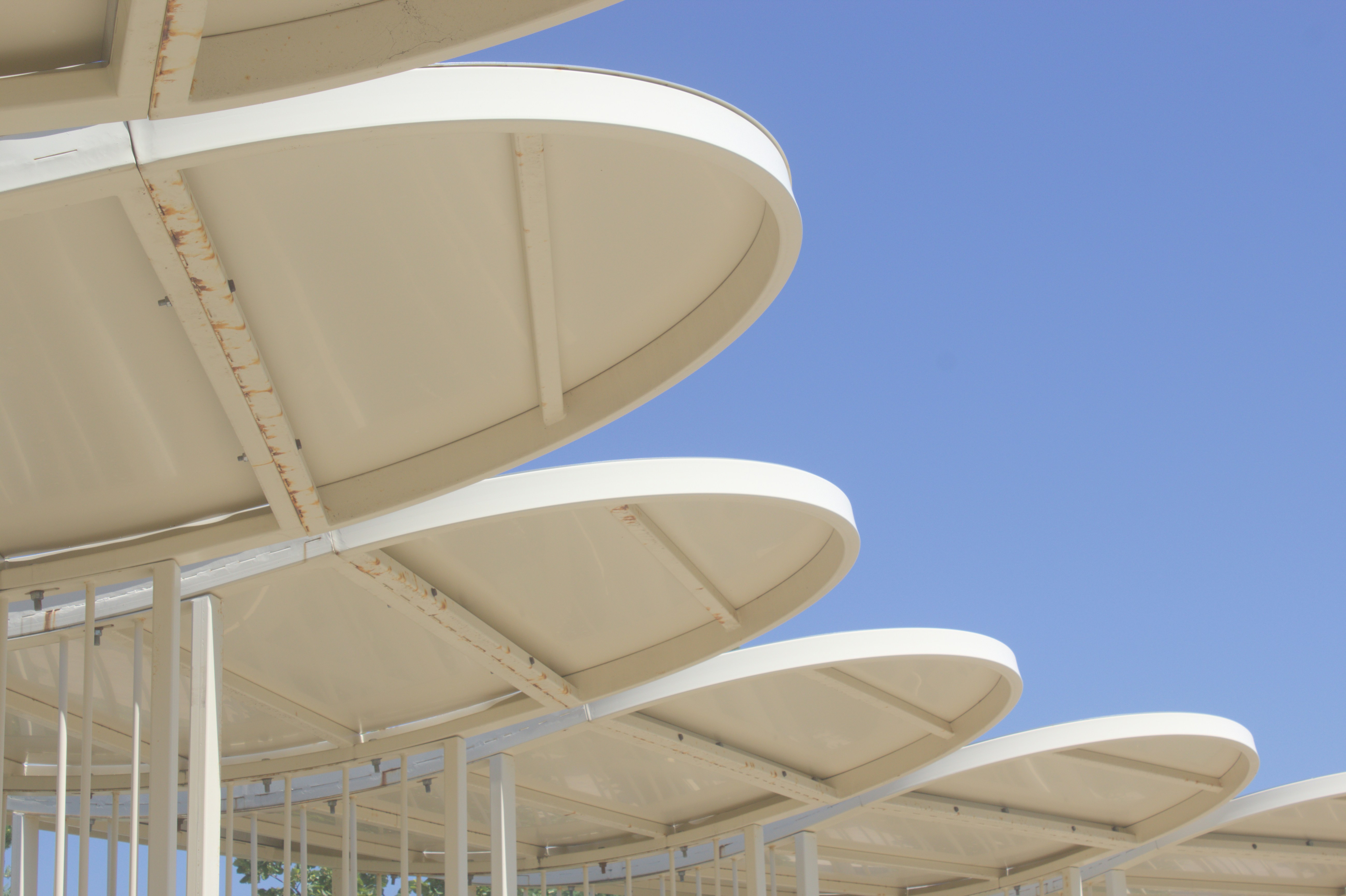 A row of curved canopies against a clear blue sky