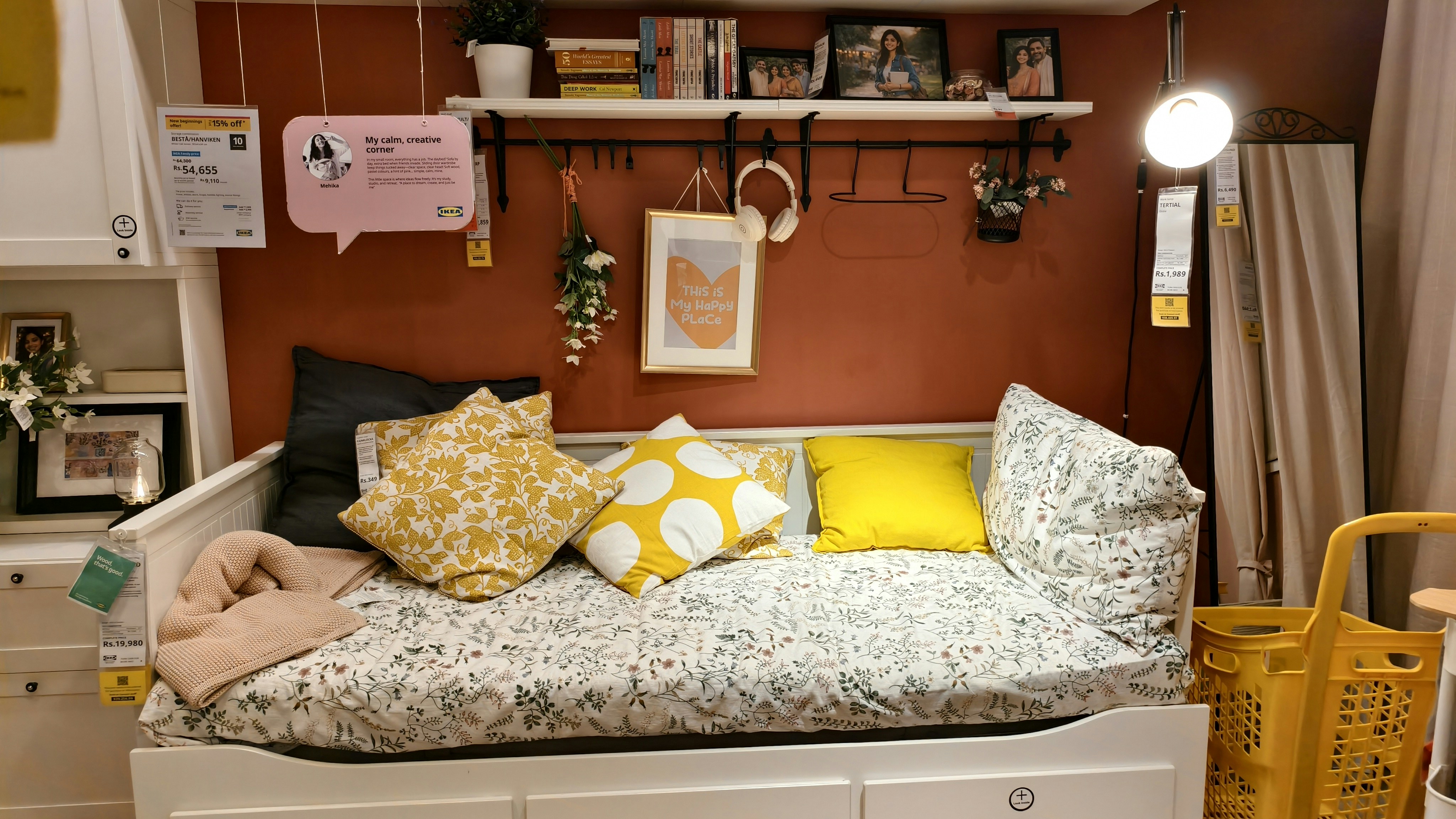 A daybed with patterned bedding and yellow pillows against a terracotta wall