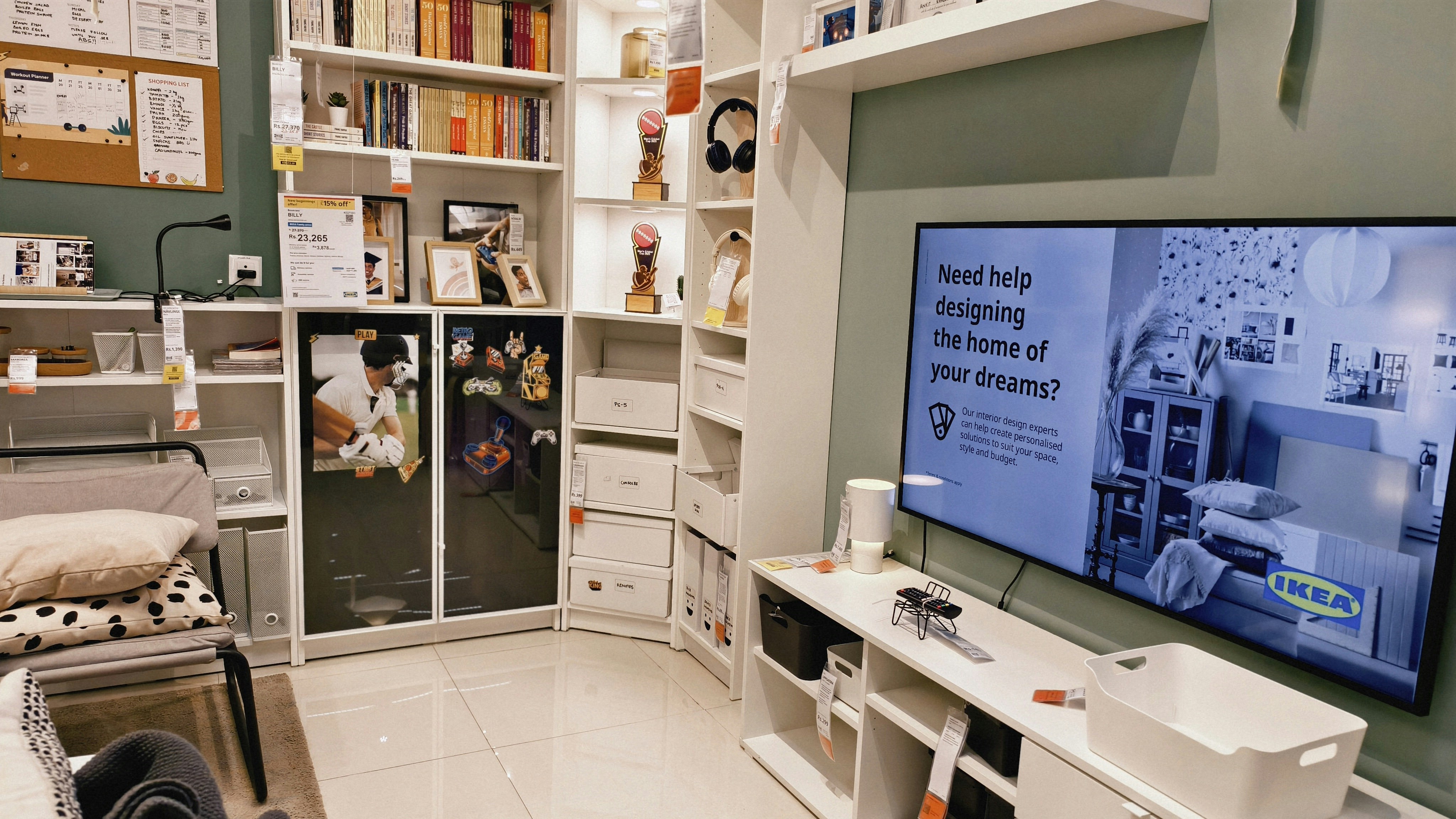 Living room corner featuring built-in storage, a large wall-mounted TV, and a small seating area with neutral tones; a calm retail-inspired interior space suited for home design inspiration.