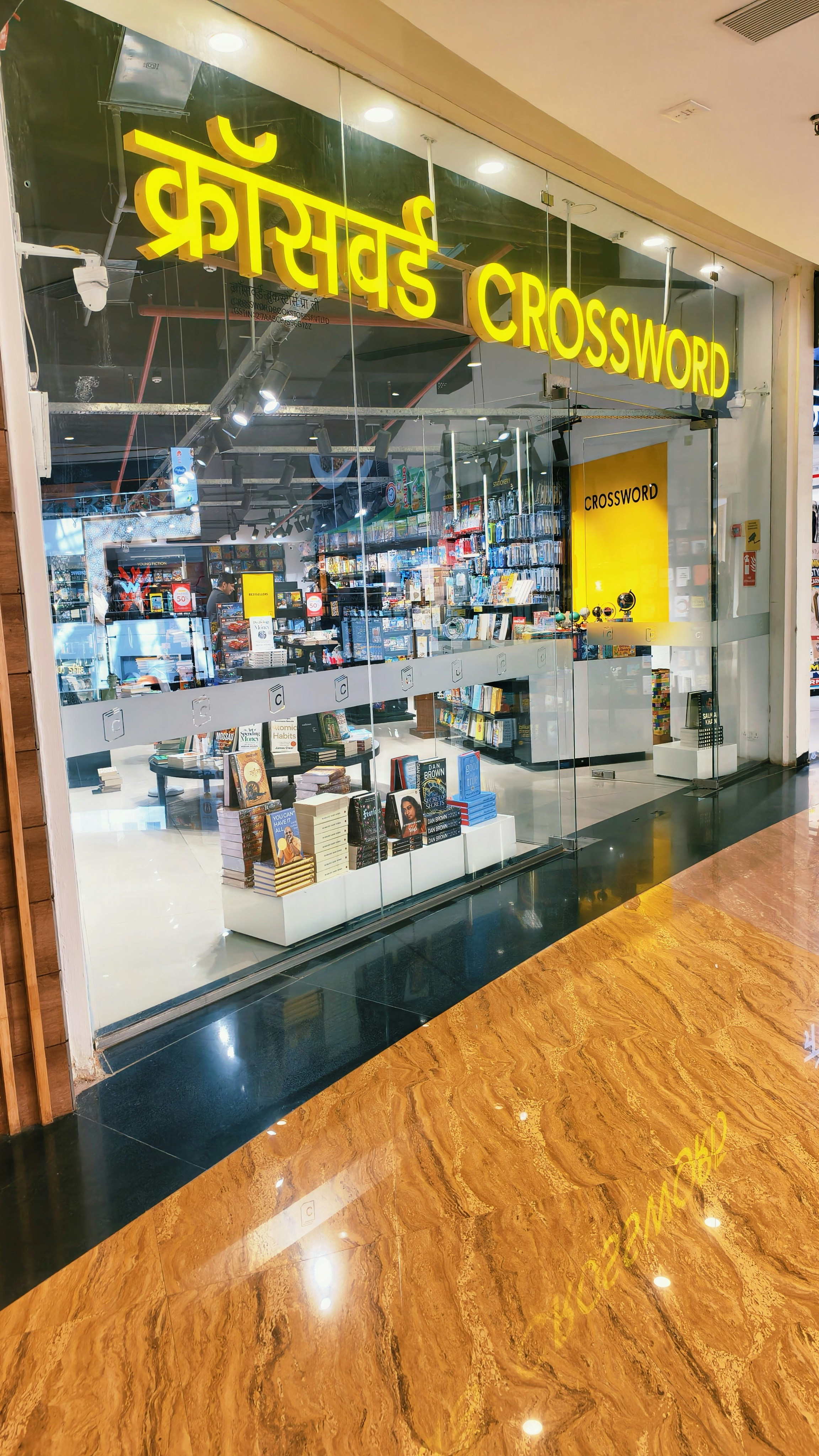 A Crossword bookstore storefront with yellow signage and books displayed in the window