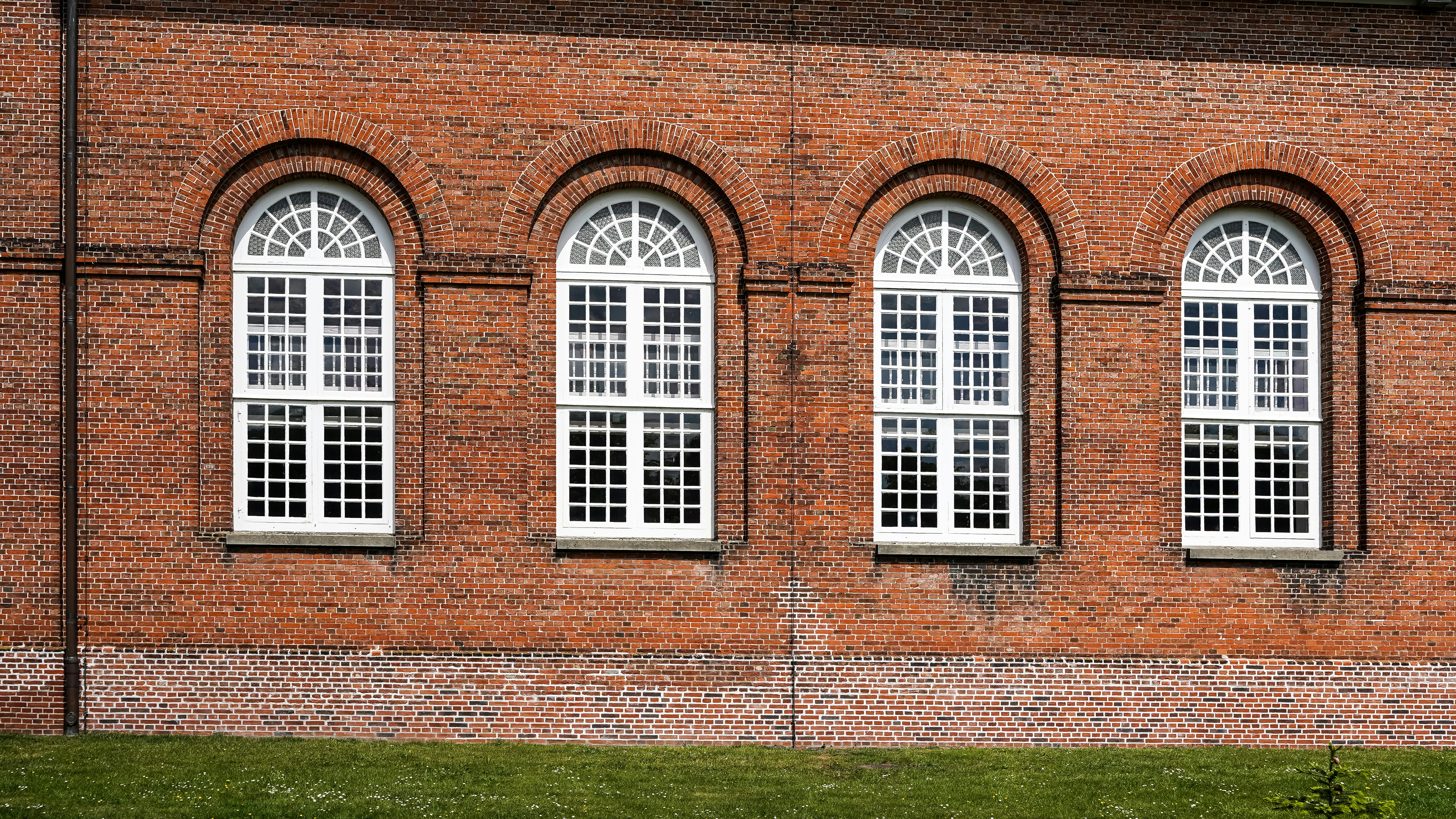 Row of Arched Windows: Brick Facade with White Lattice Panes
