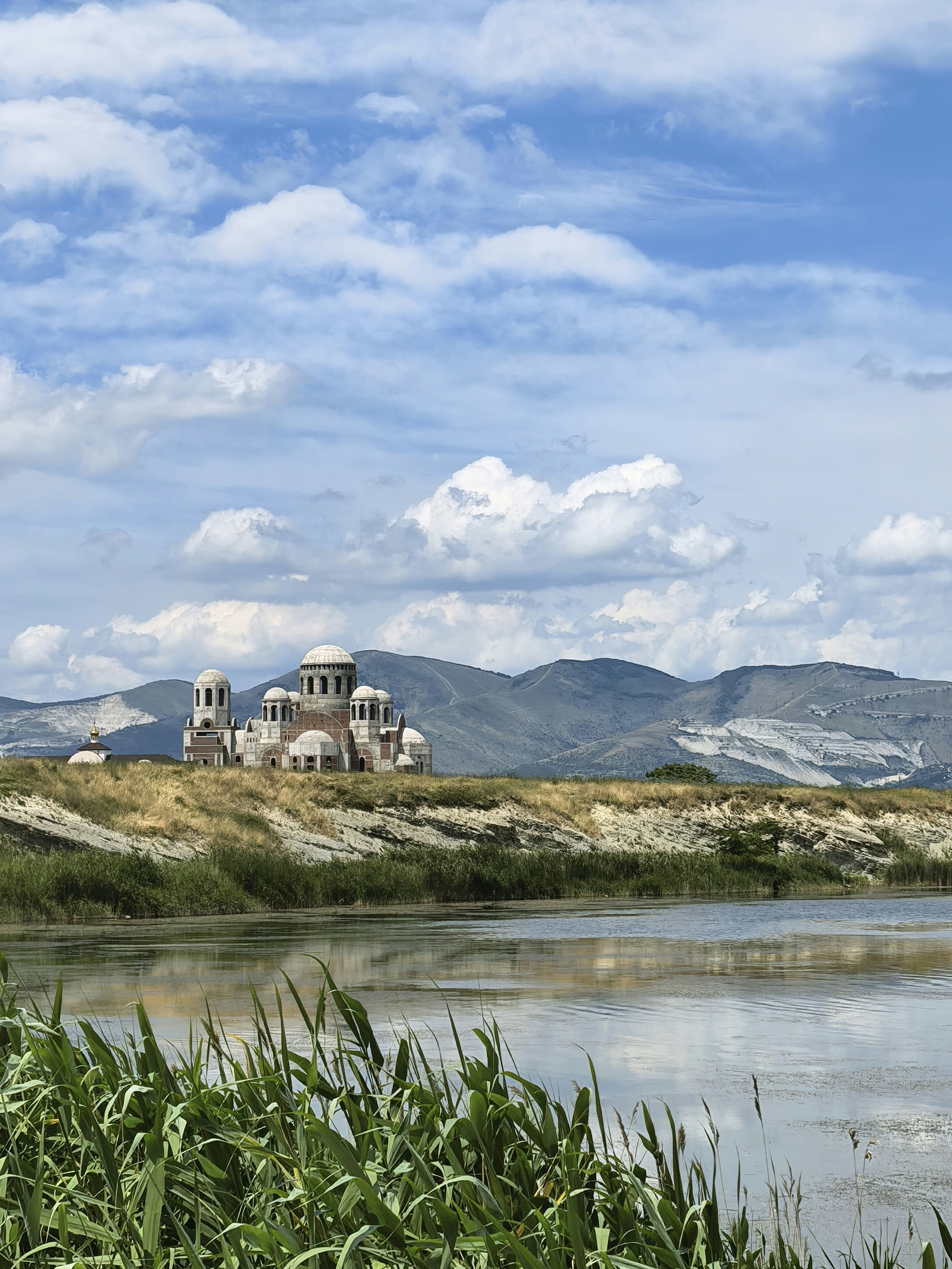 Domes and Dunes: A Riverside Sanctuary with Clouded Sky