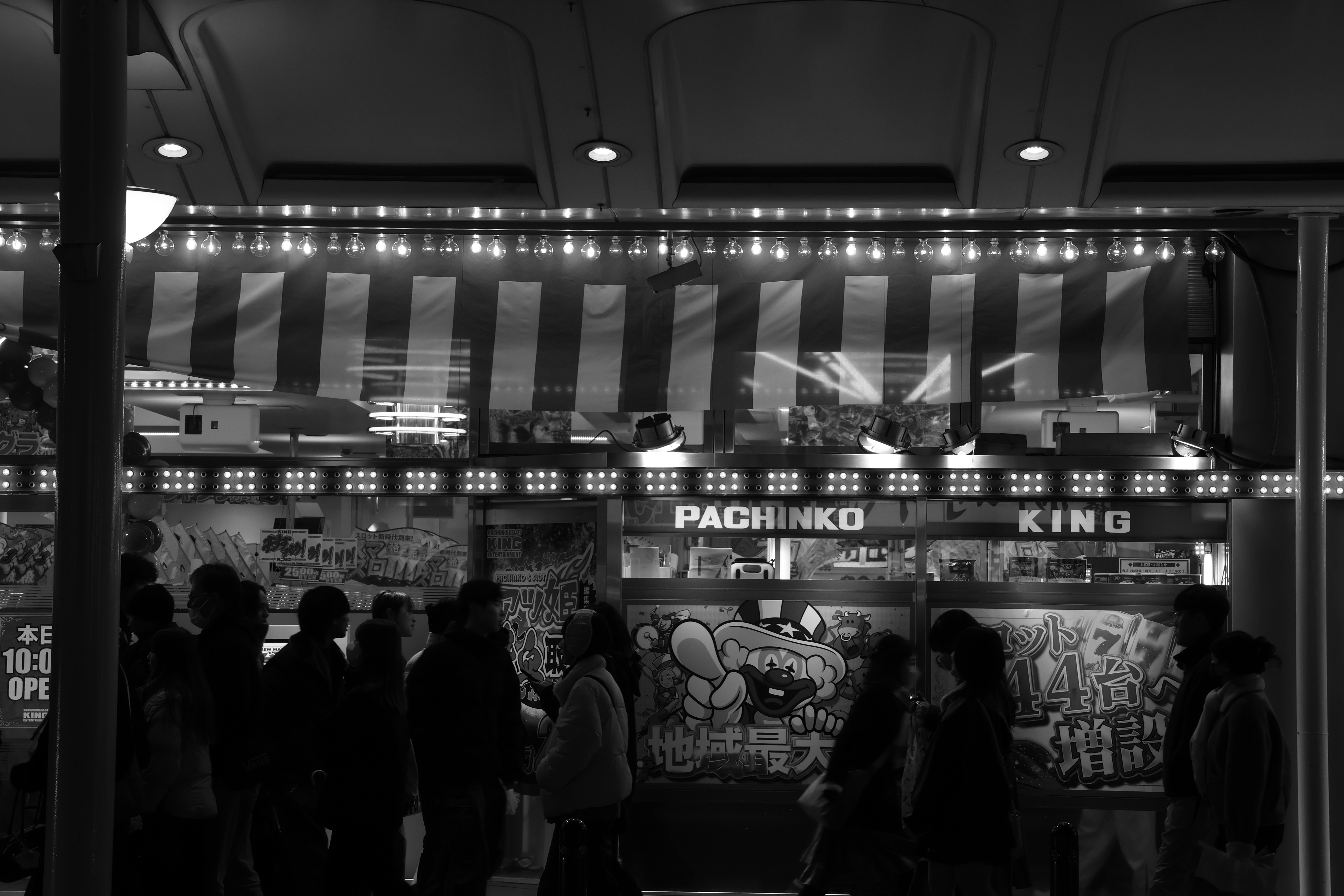 Neon Strip and Crowd Amid Shaded Arcade Signs