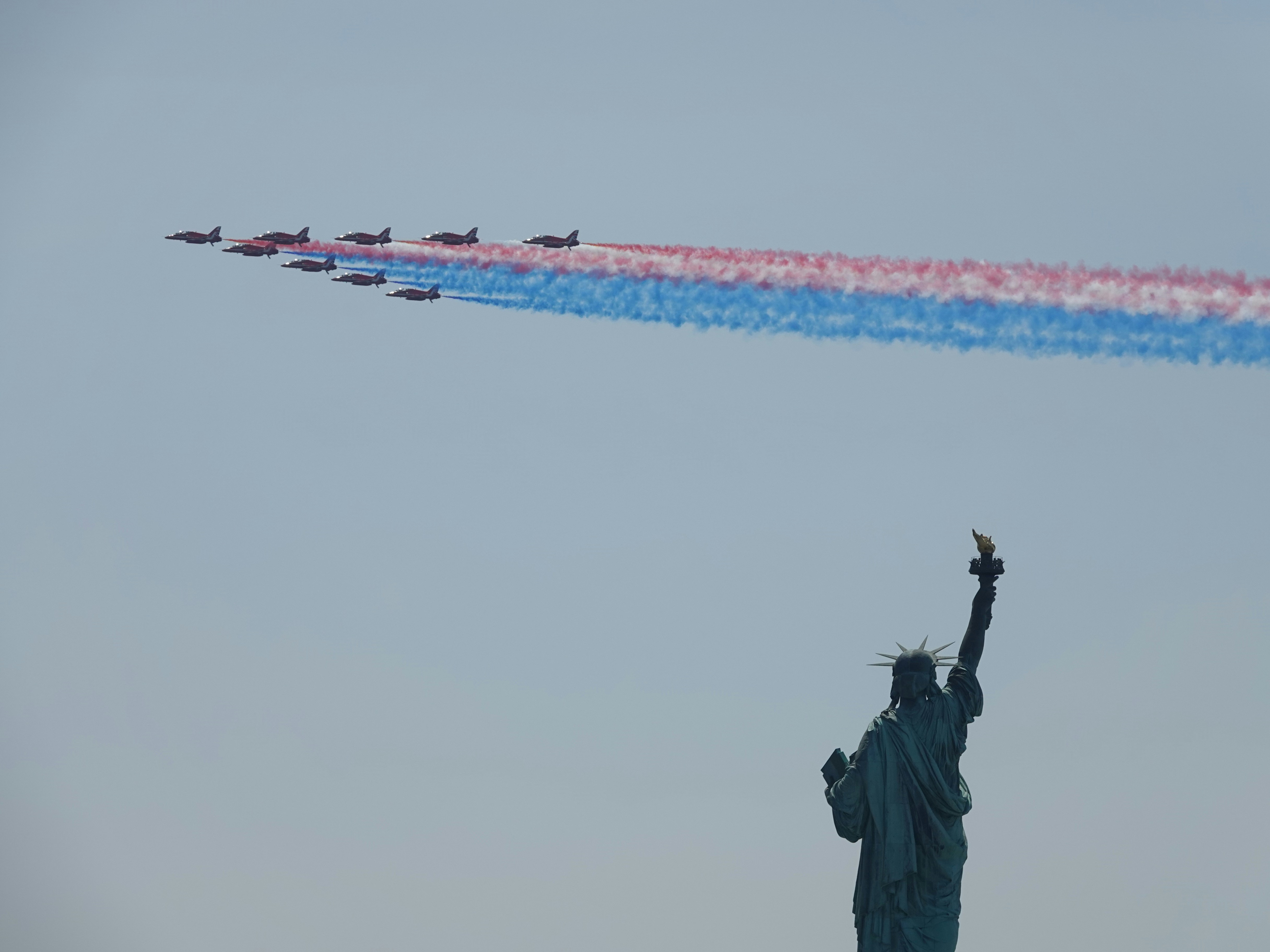 Red, White, and Sky–formidable aerial parade above the statue