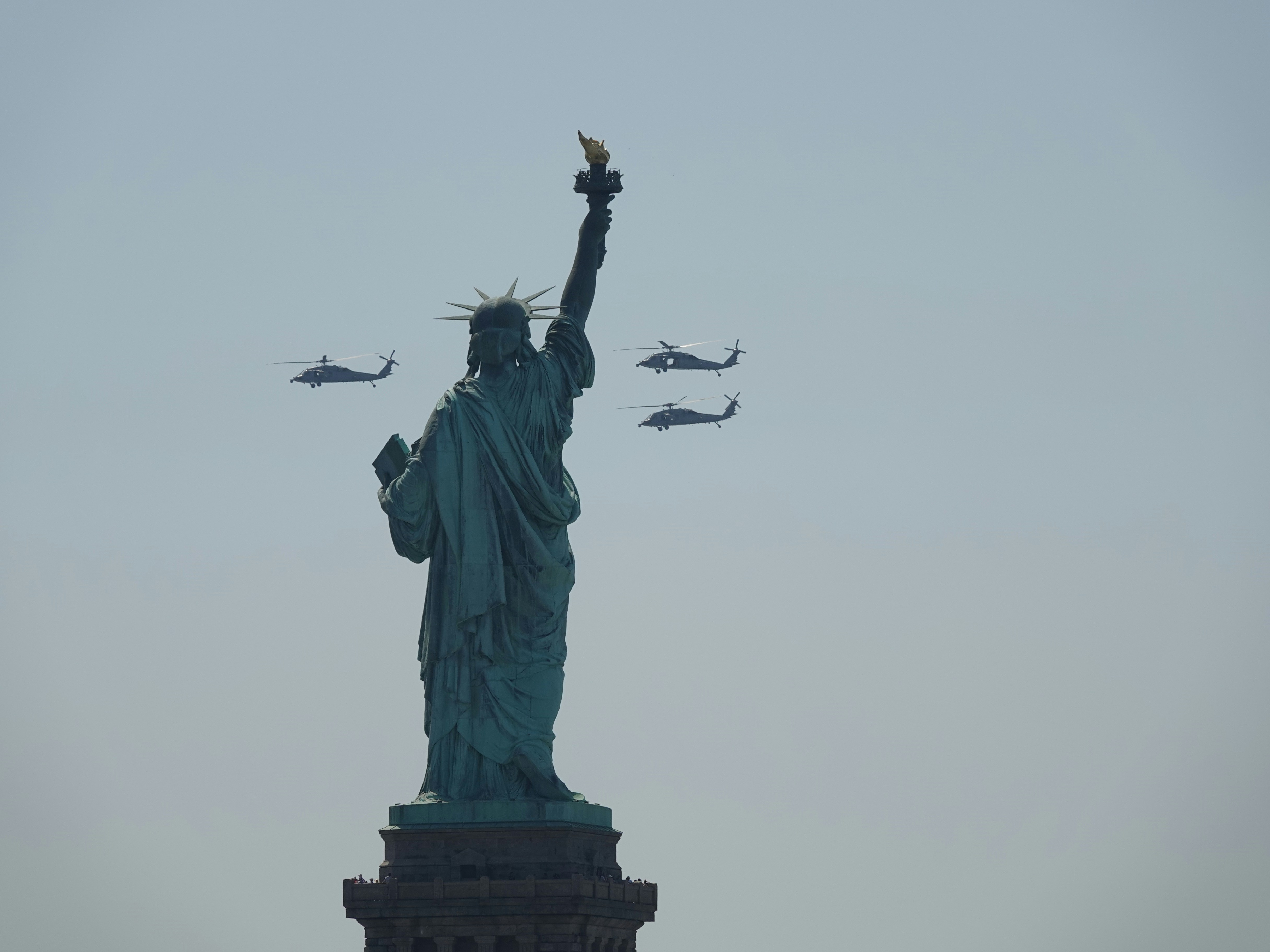 Liberty Silhouette Under a Sky of Drones