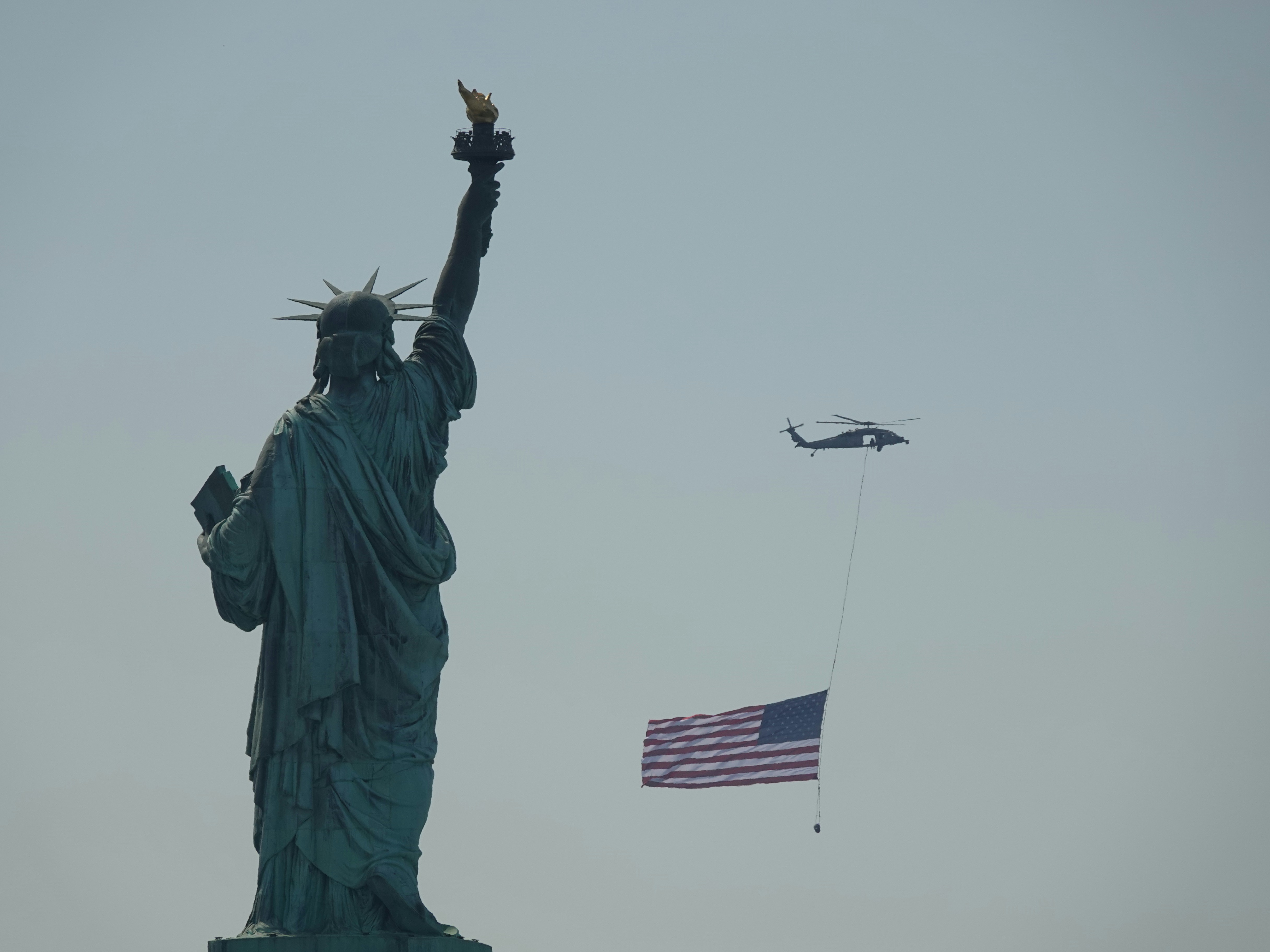 Liberty Lift: A Flag Drifts Beneath a Sentinel Sky