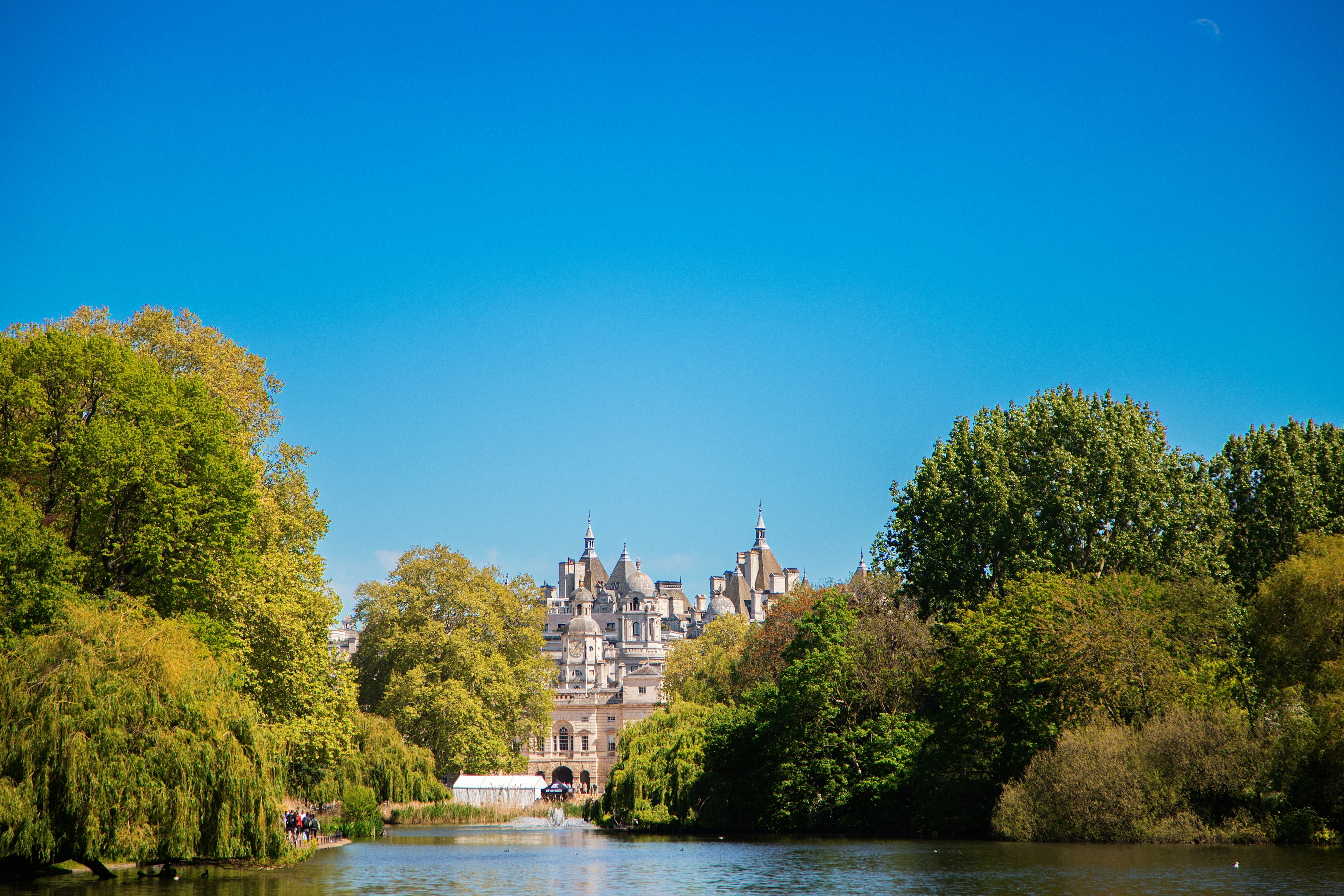 Castle Framed by Riverside Canopy Under a Clear Autumn Sky