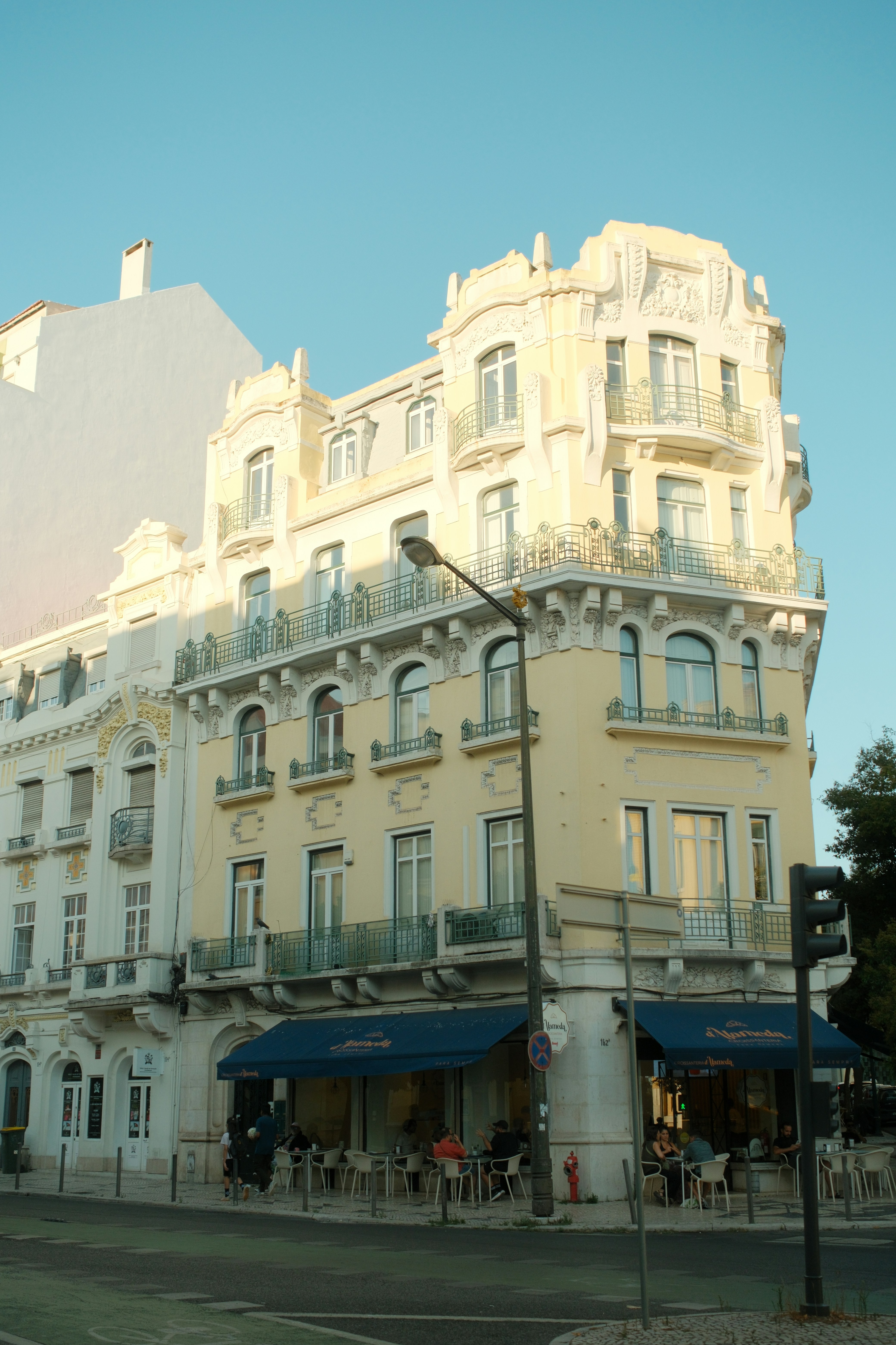 Sunlit Belle Époque Facade Overlooking a Café Terrace