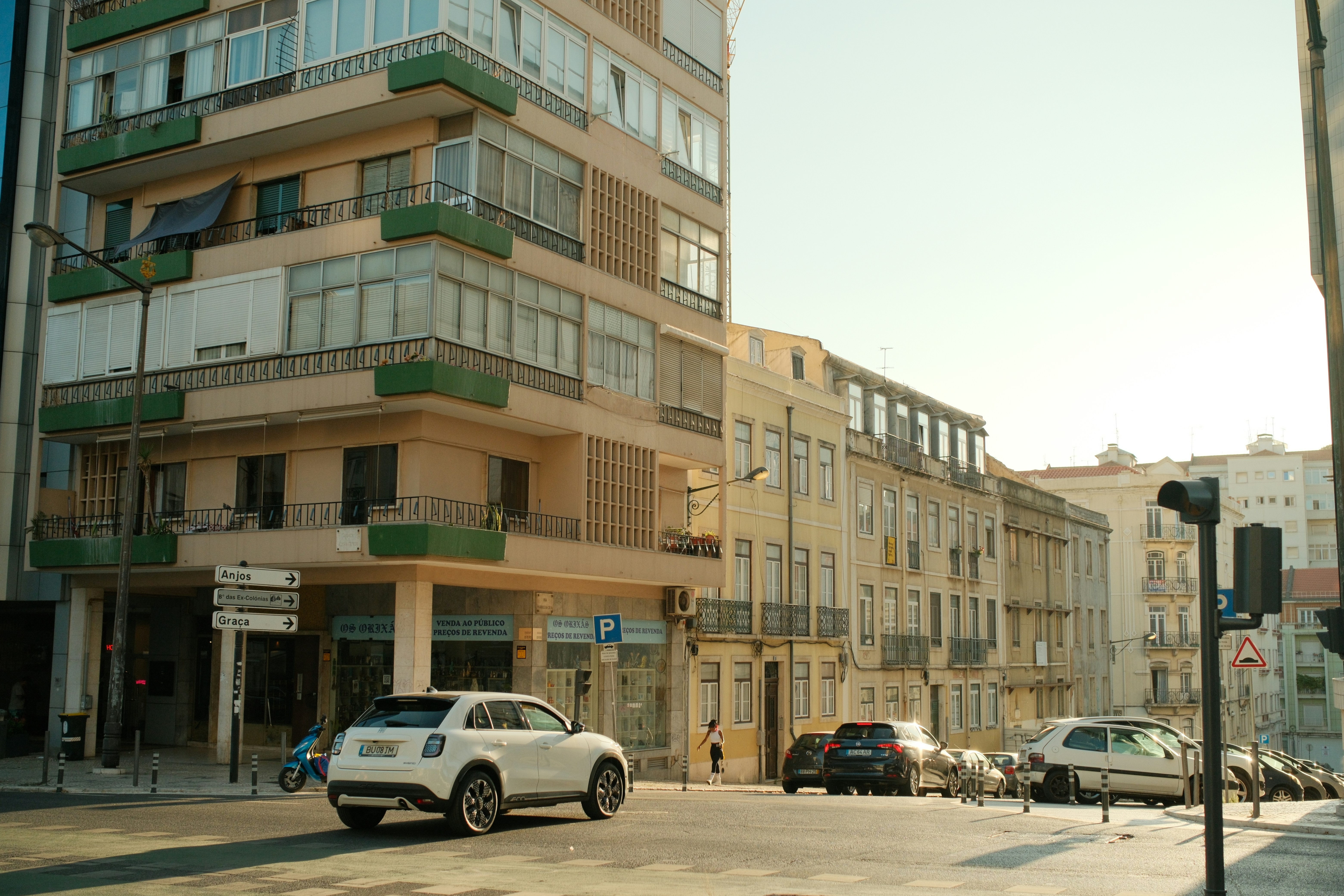 Sunlit Street Level: Cars, Signposts and a Cornered Bakery