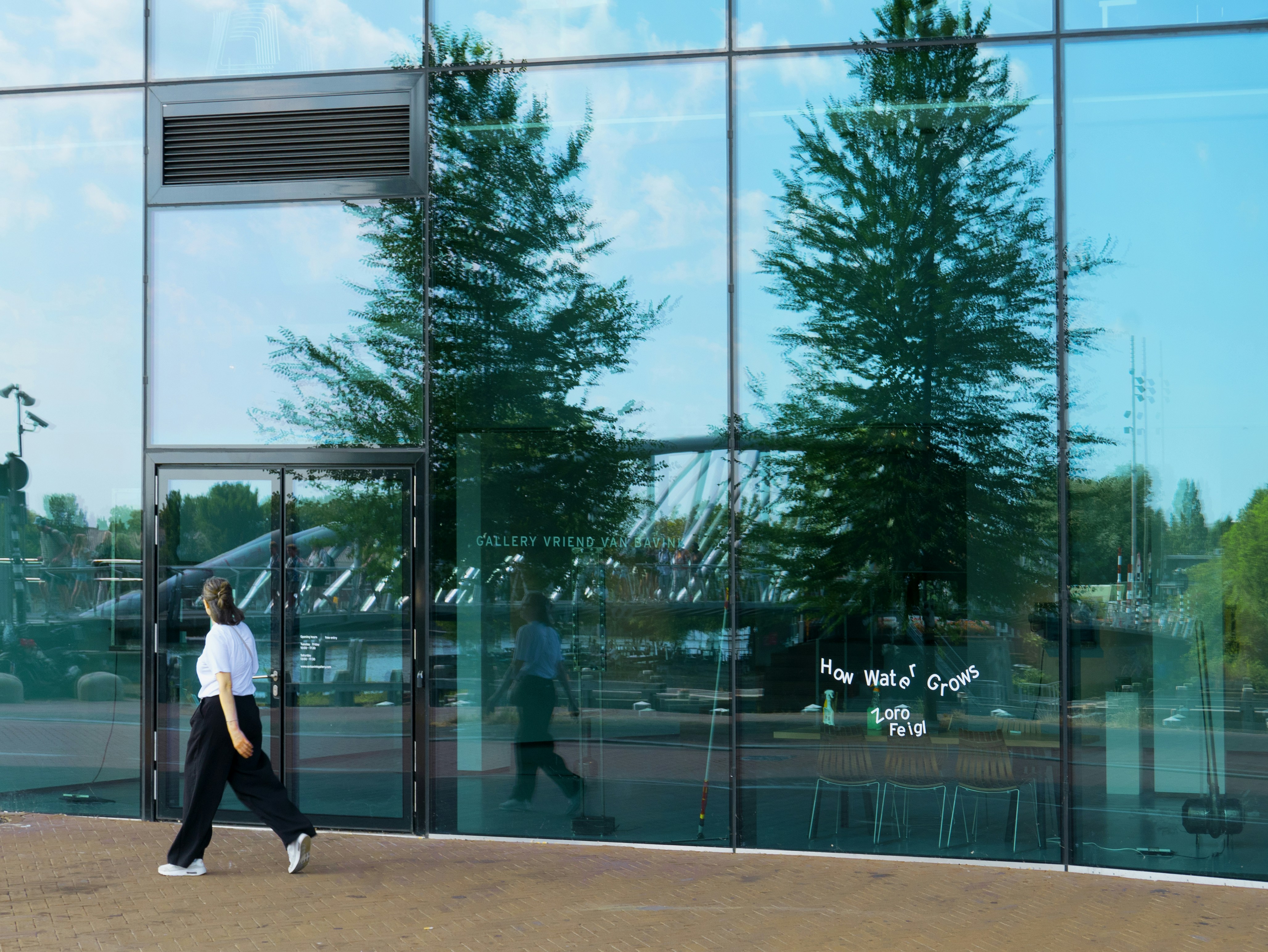 Reflections and footsteps: a passerby against modern glass