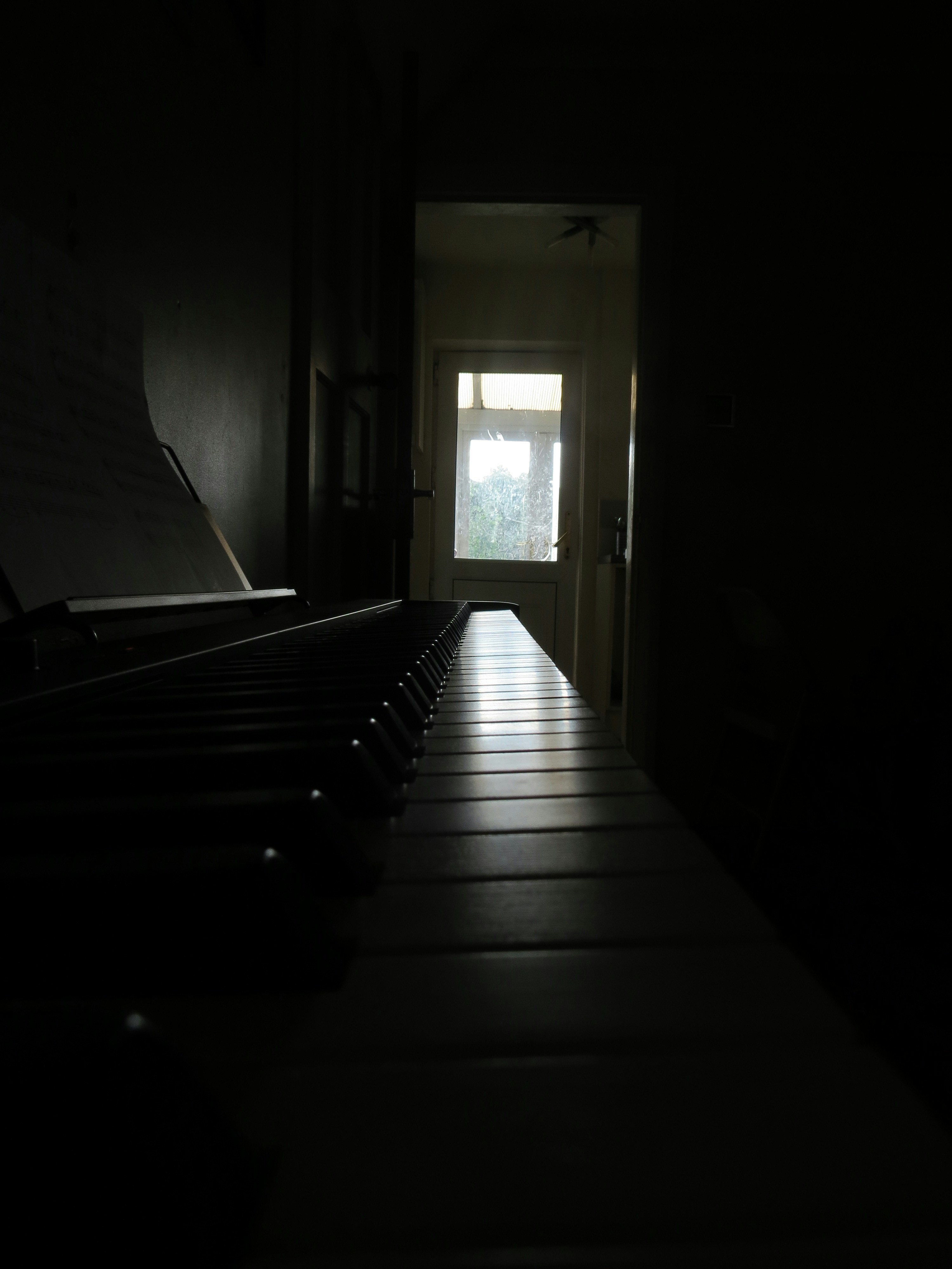 Dim Corridor to Lighted Doorway: A Piano Bench Leads the Eye