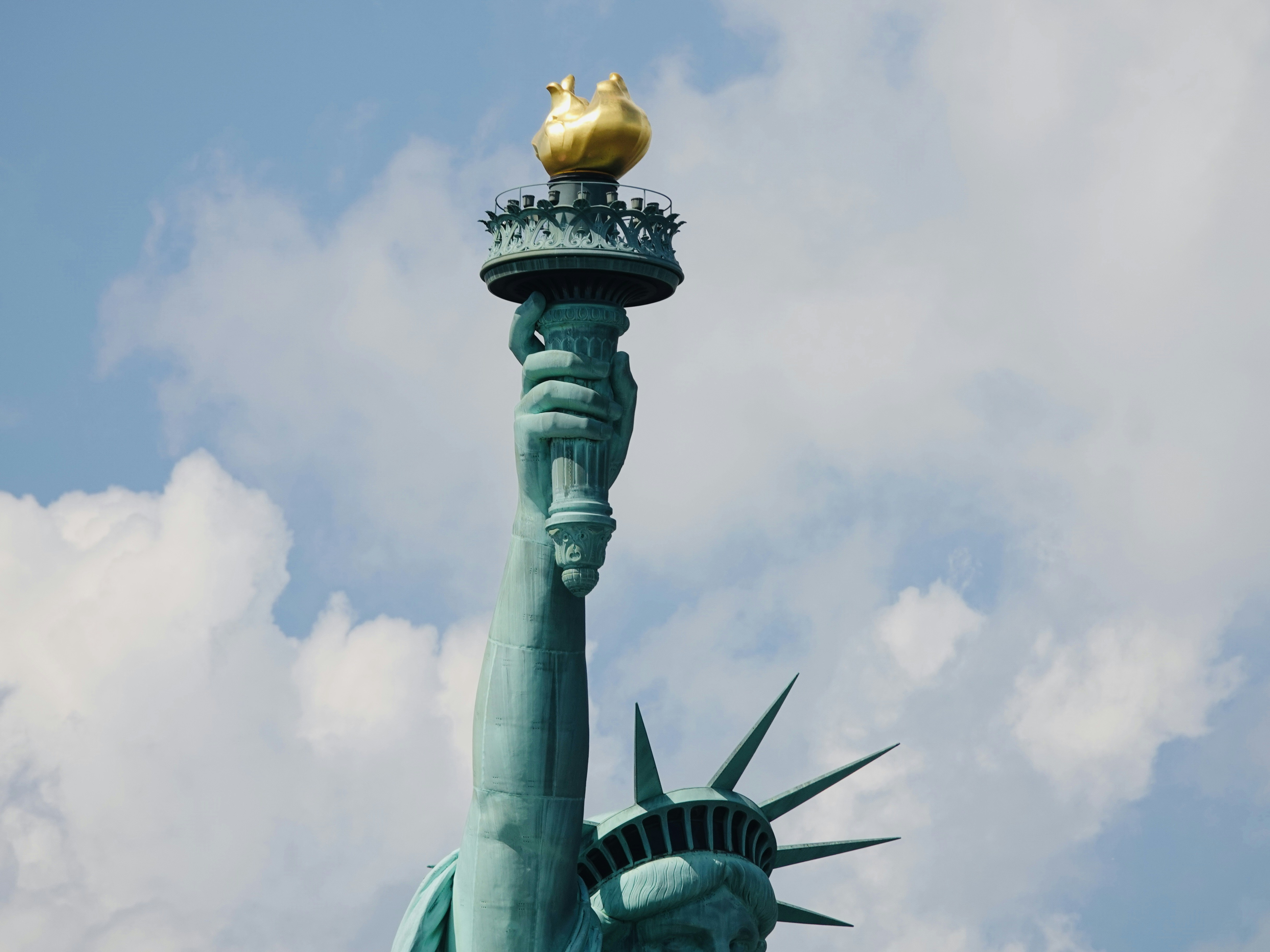 Crown of Liberty: the torch-bearing statue rises against a bright sky