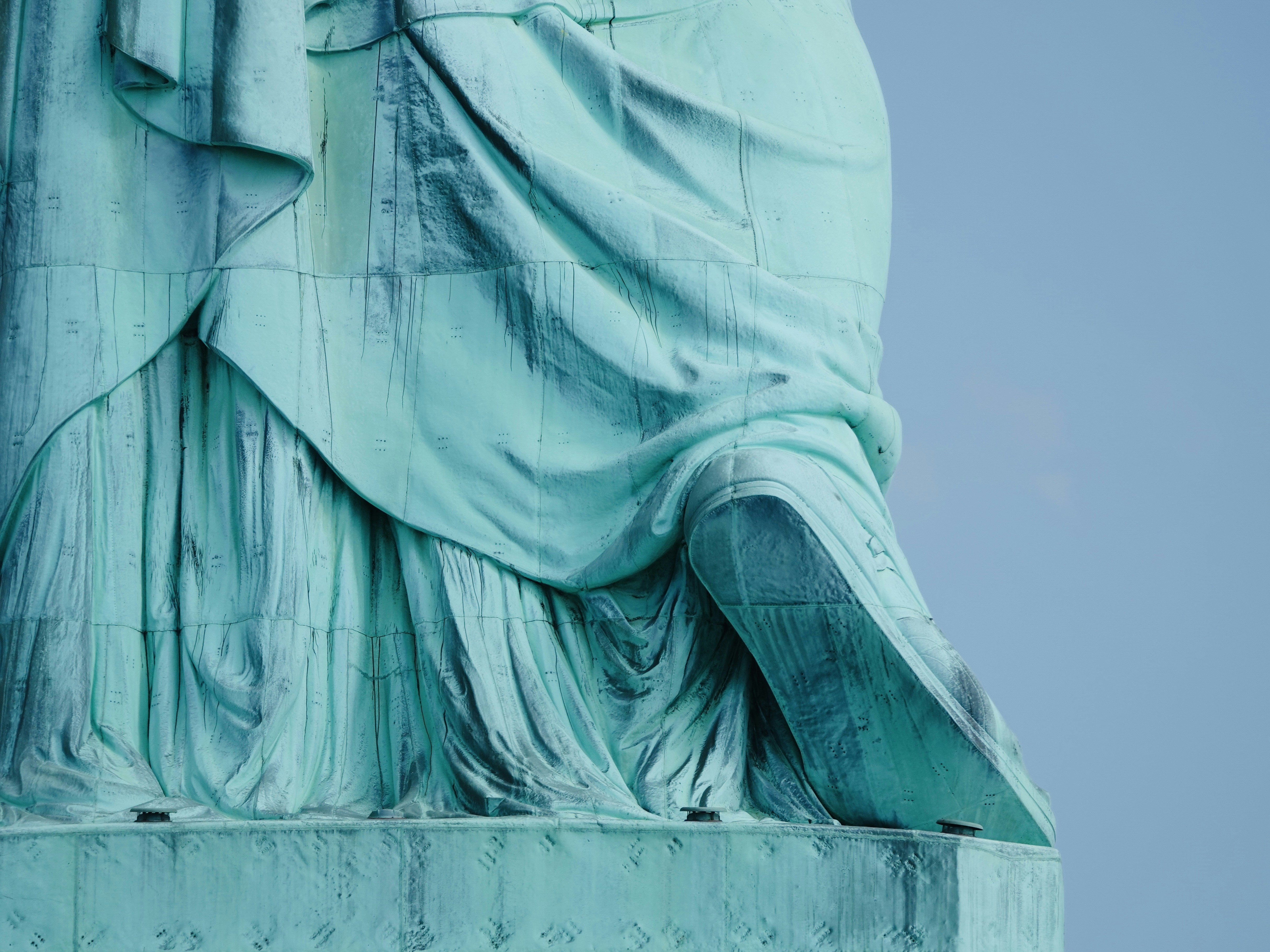 Patina at the pedestal: the draped robe of a monumental statue
