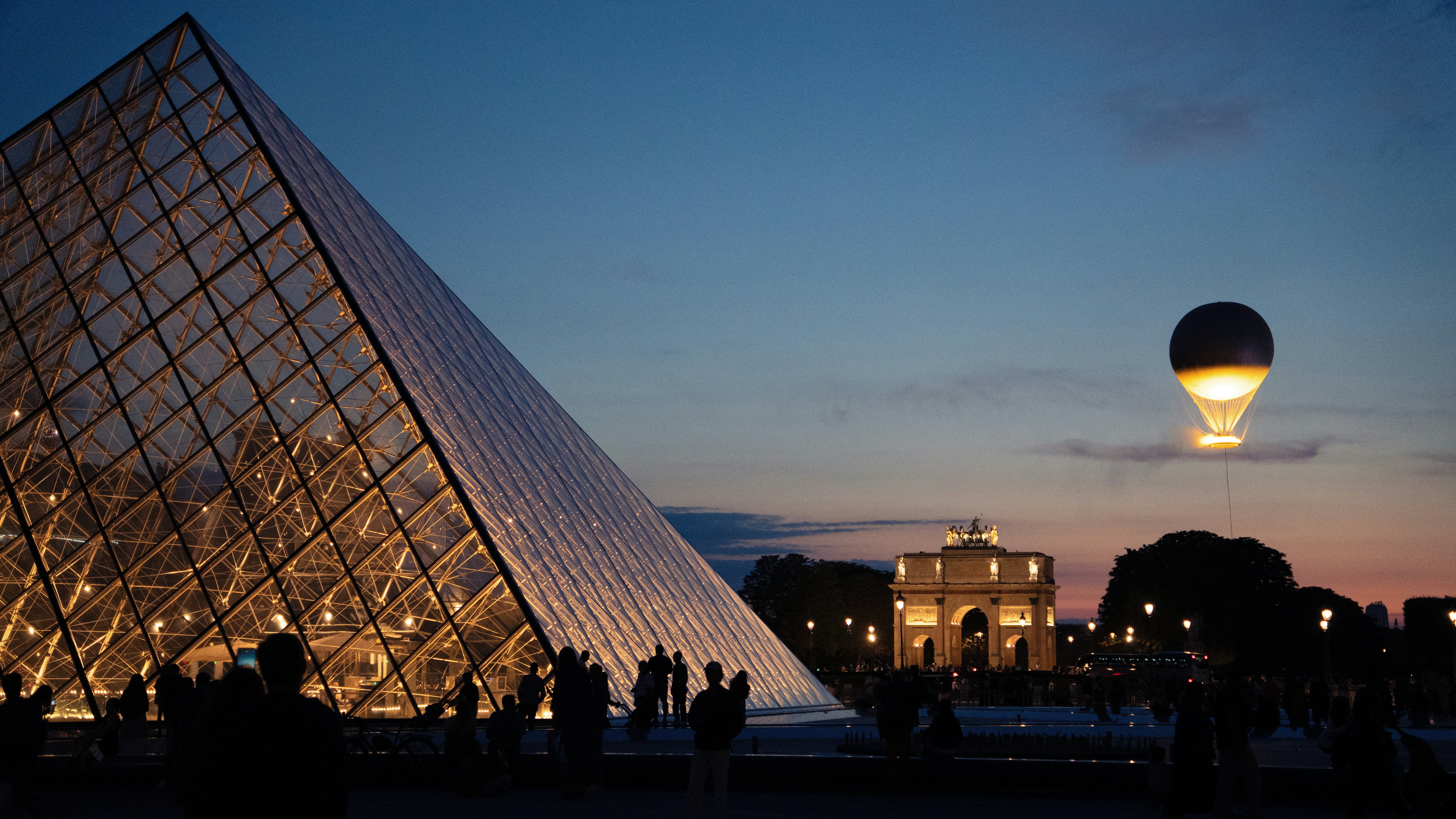 Dusk at the Glass Pyramid: Shadows, Lights, and Arcaded Echoes